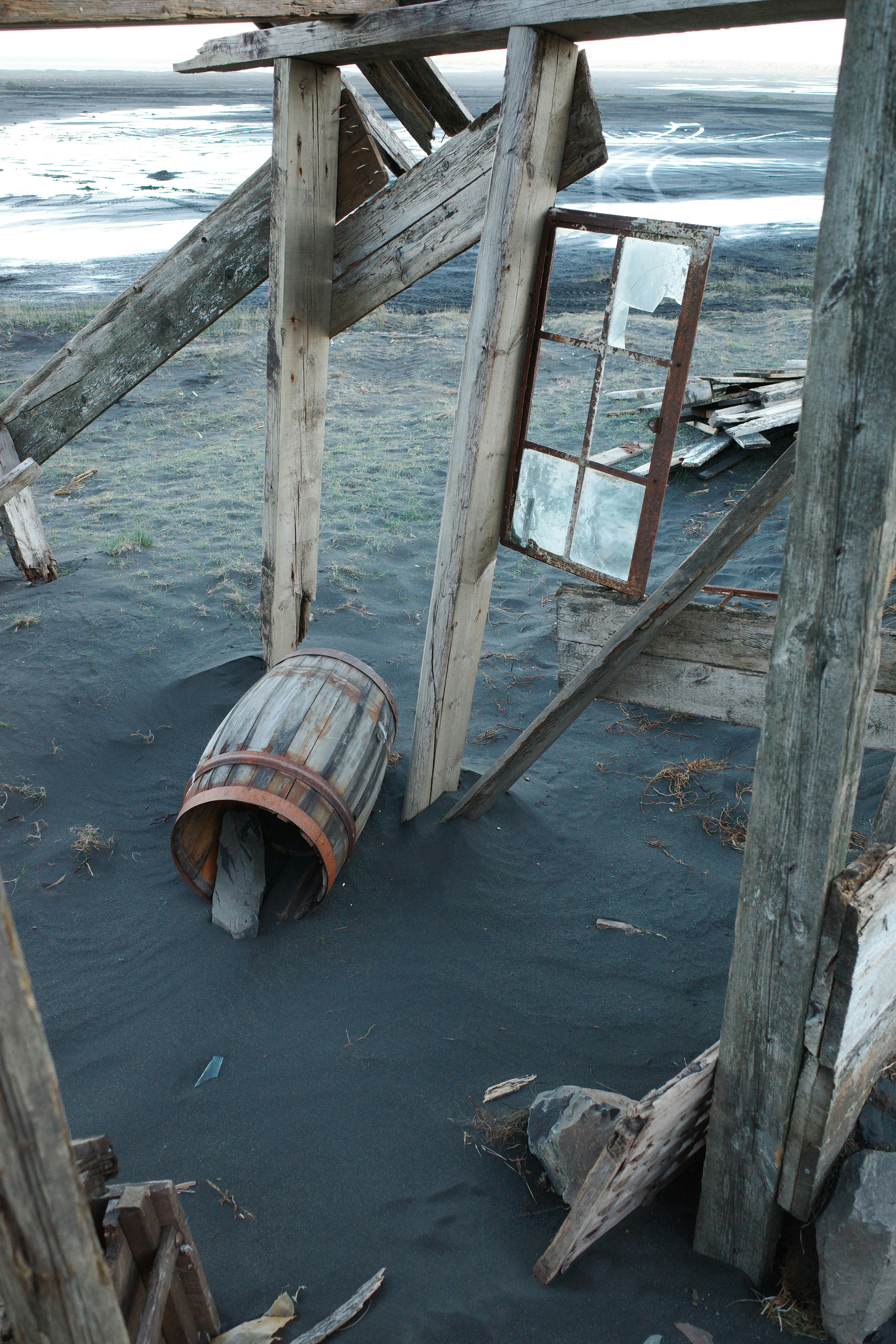Sunken Workshop by the Tide: A Crumbling Frame and Barrel in Muddy Light
