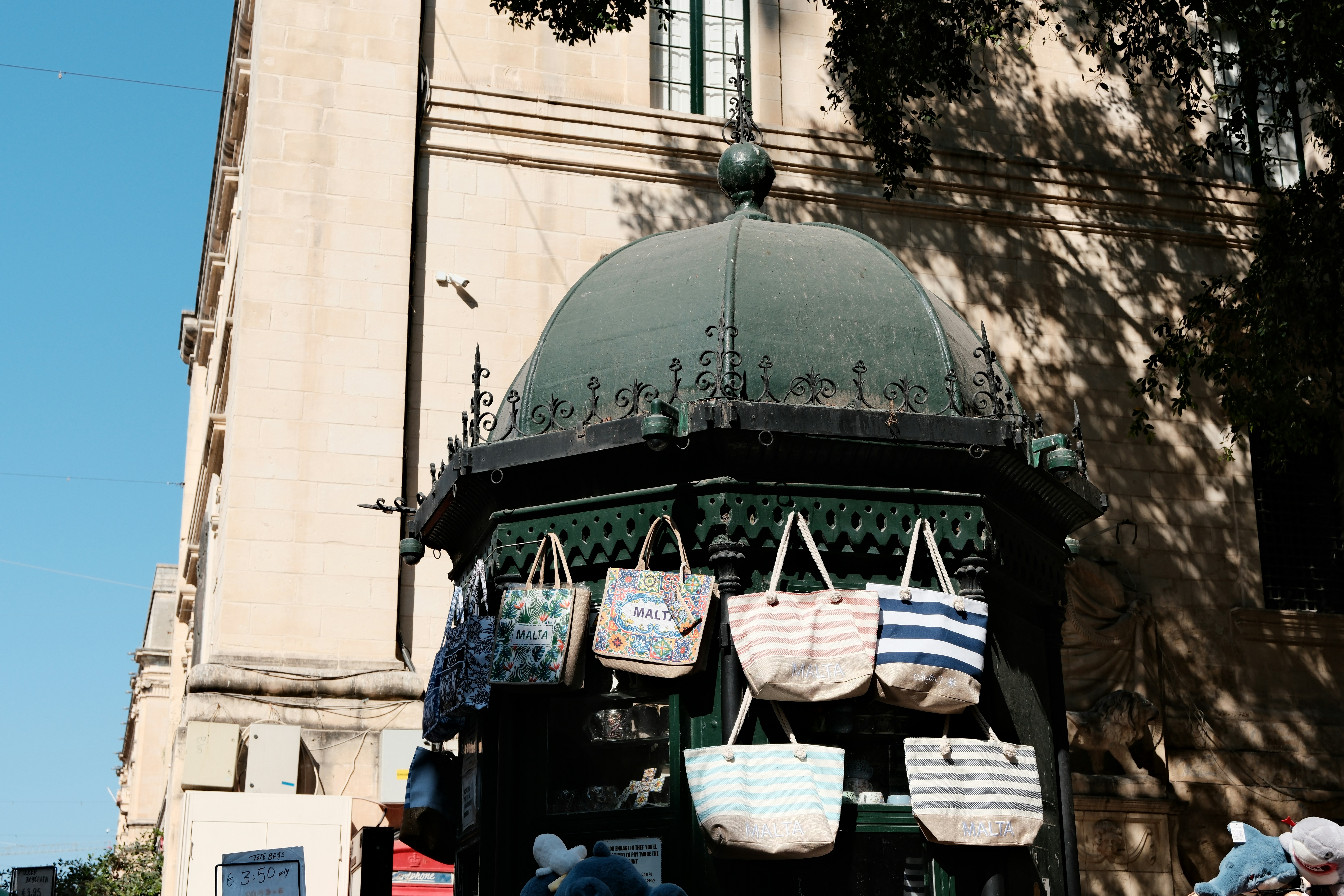 Straw tote stalls under a tiled green kiosk dome