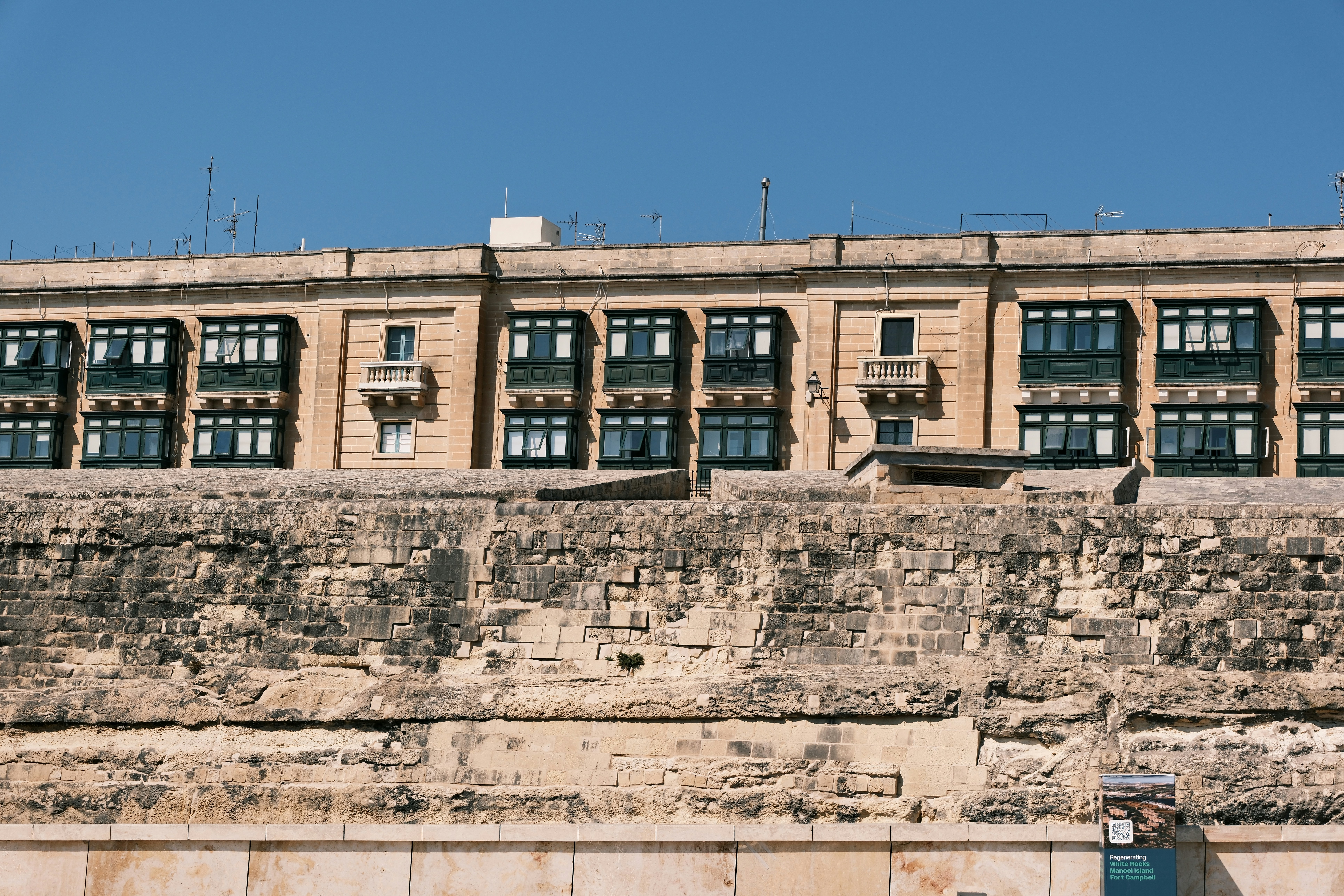 Old Quarry Facade: Windows and Stonework Beneath a Clear Sky