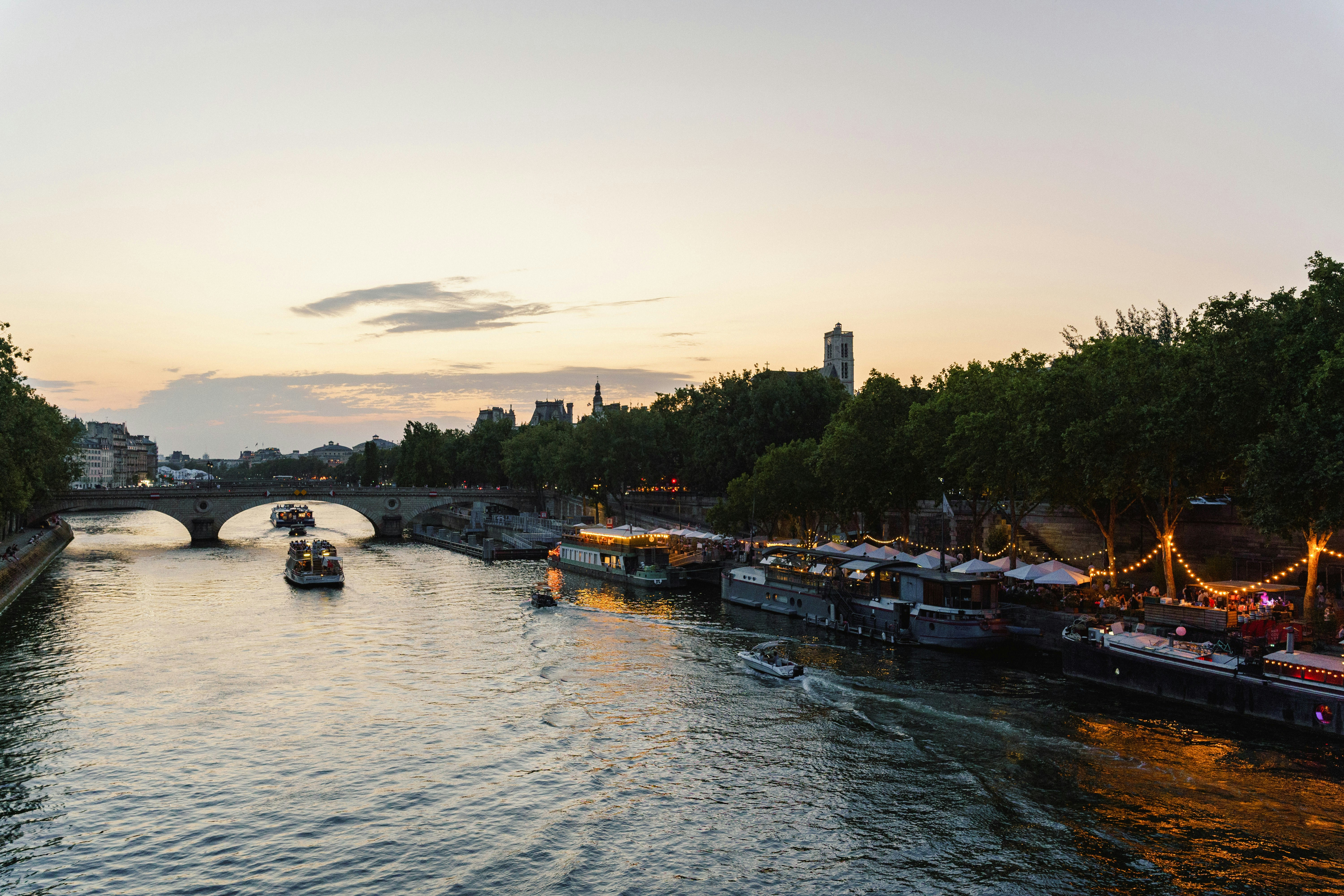 Evening Boats along the Seine: Lanterns, Water, and Skyline