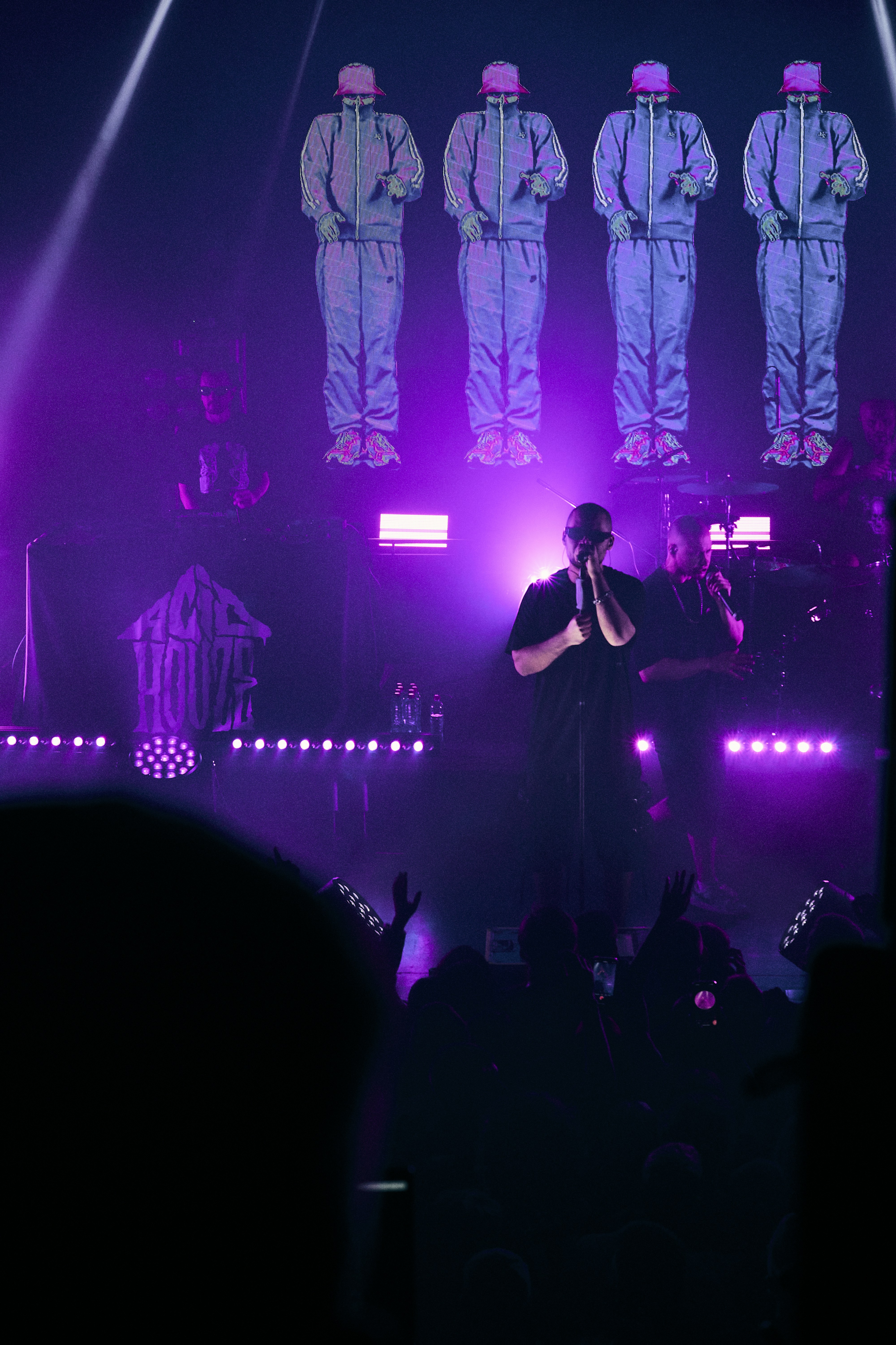 Midnight Waves: A quartet of spectral performers and the lead singer under violet spotlight