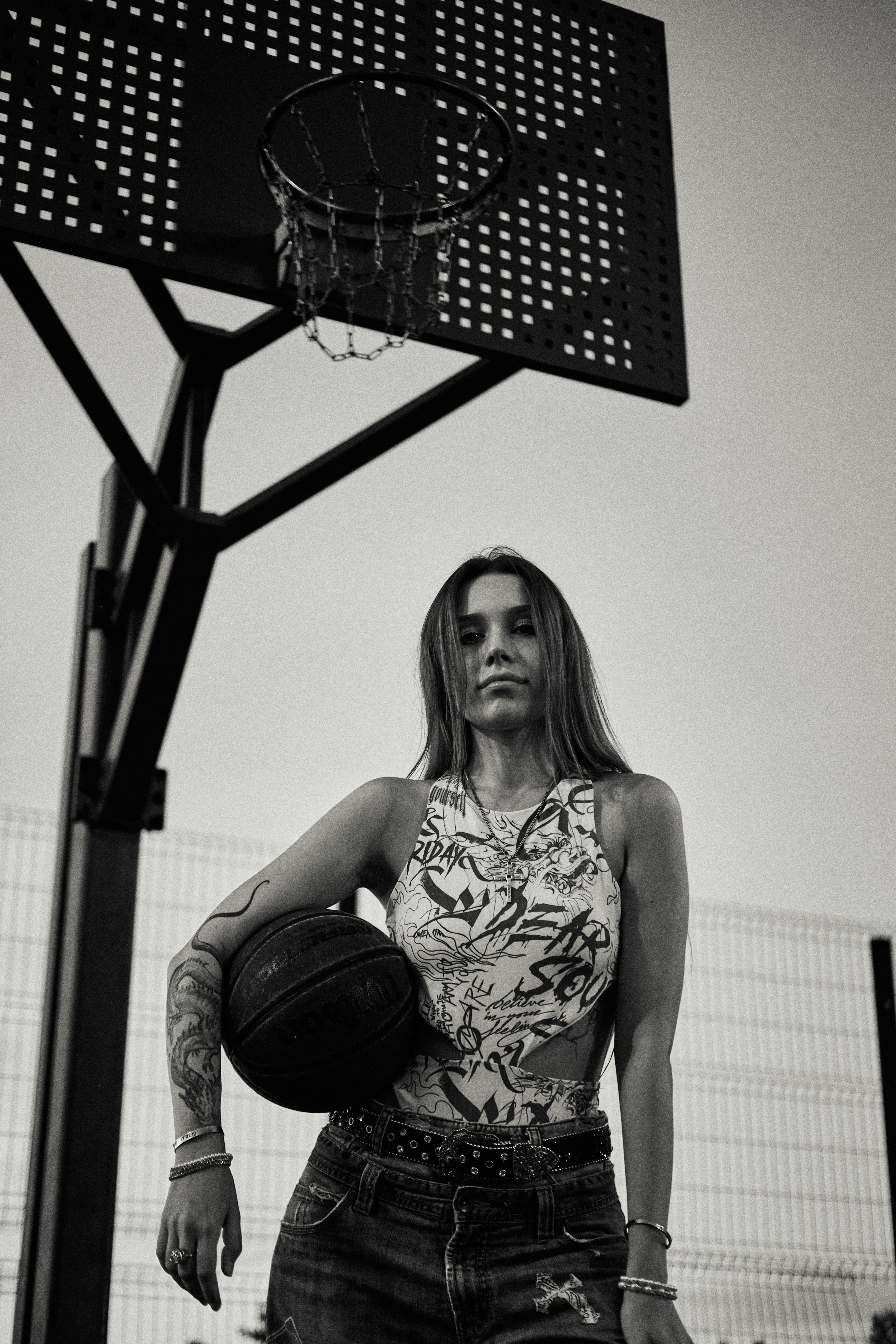 Courtside Confidence: A Basketball Player Leaning Against the Hoop