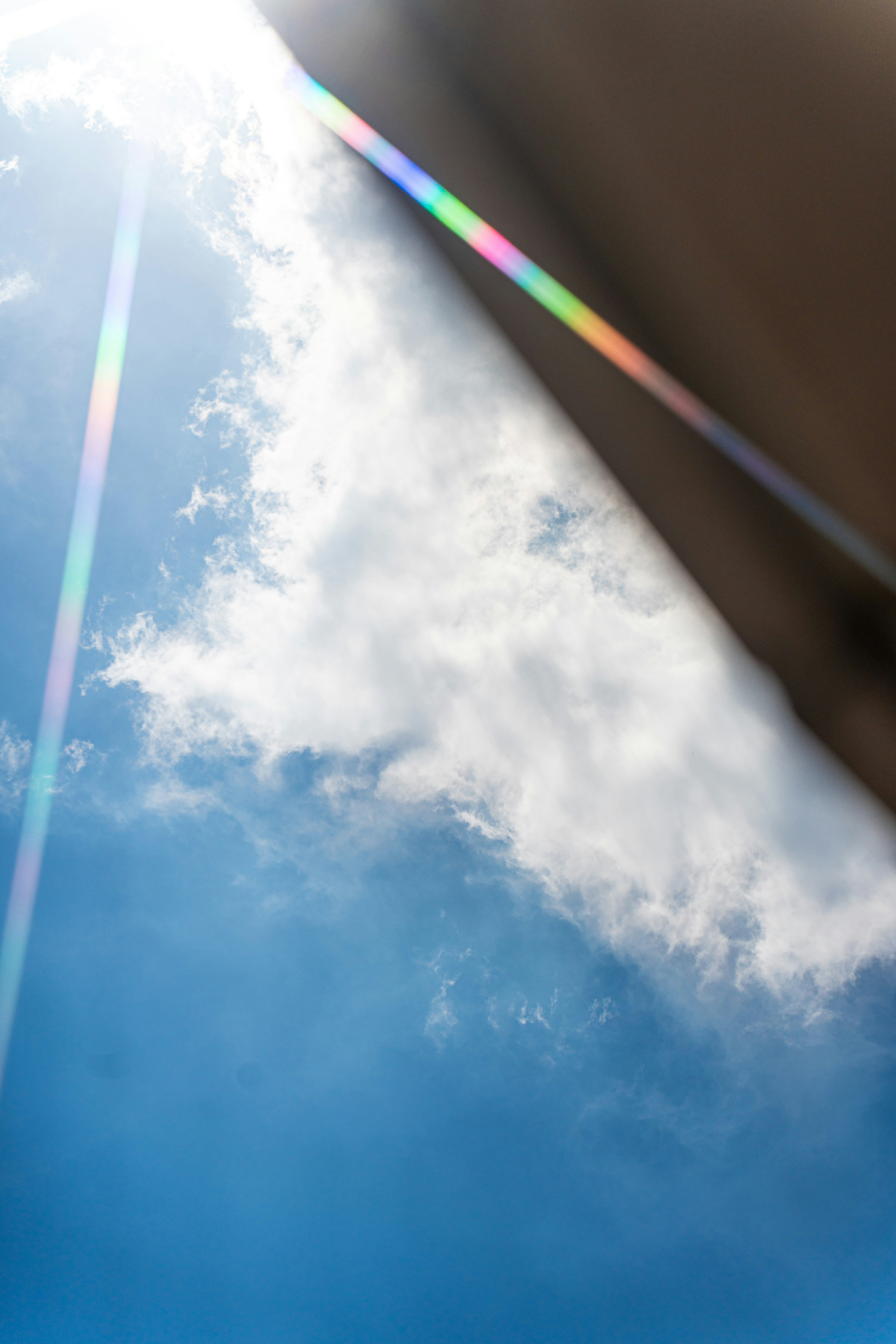 Rainbow light fracture across a sunlit sky