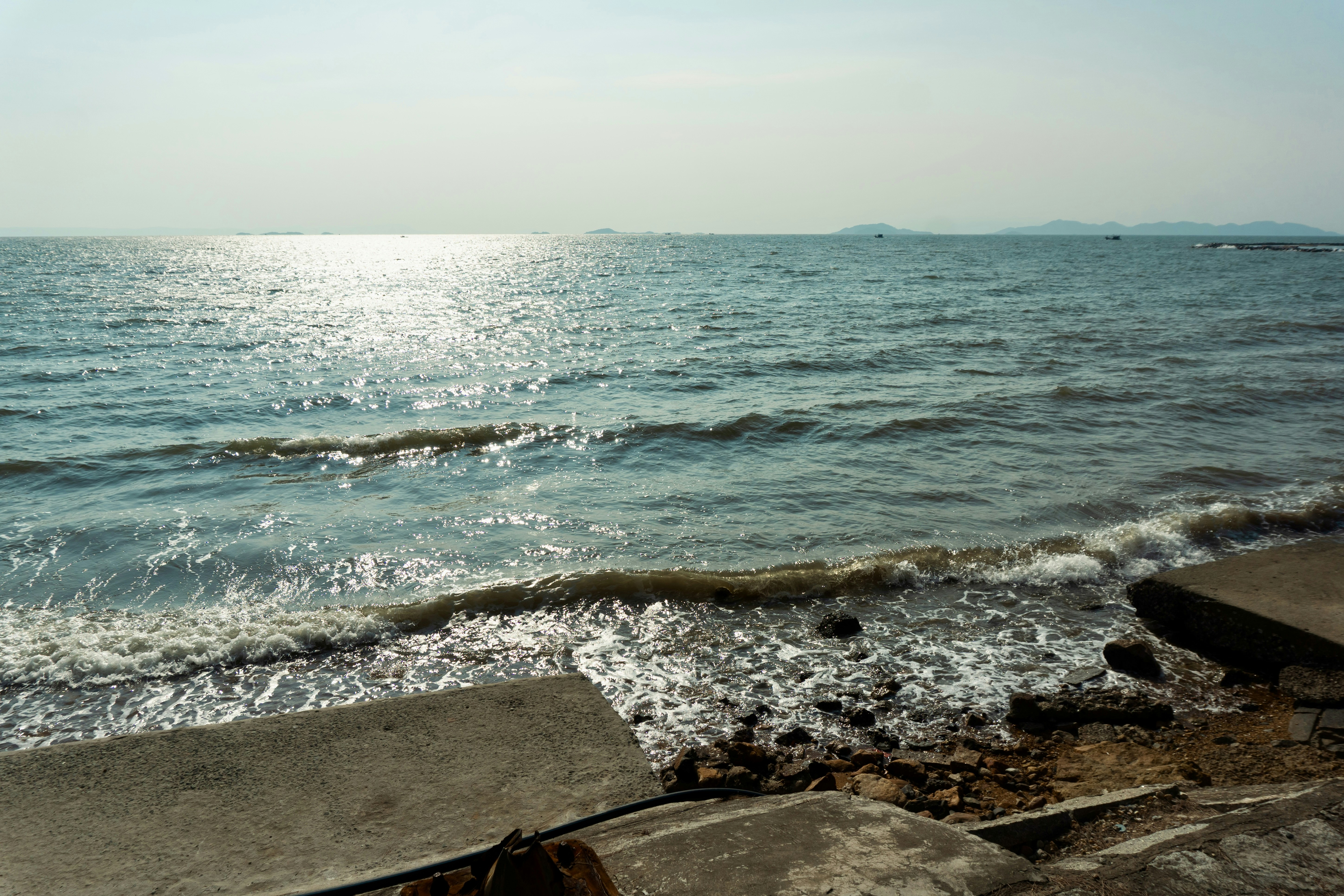 Sunlit Sea Whisper: A Quiet Moment by the Breakwater