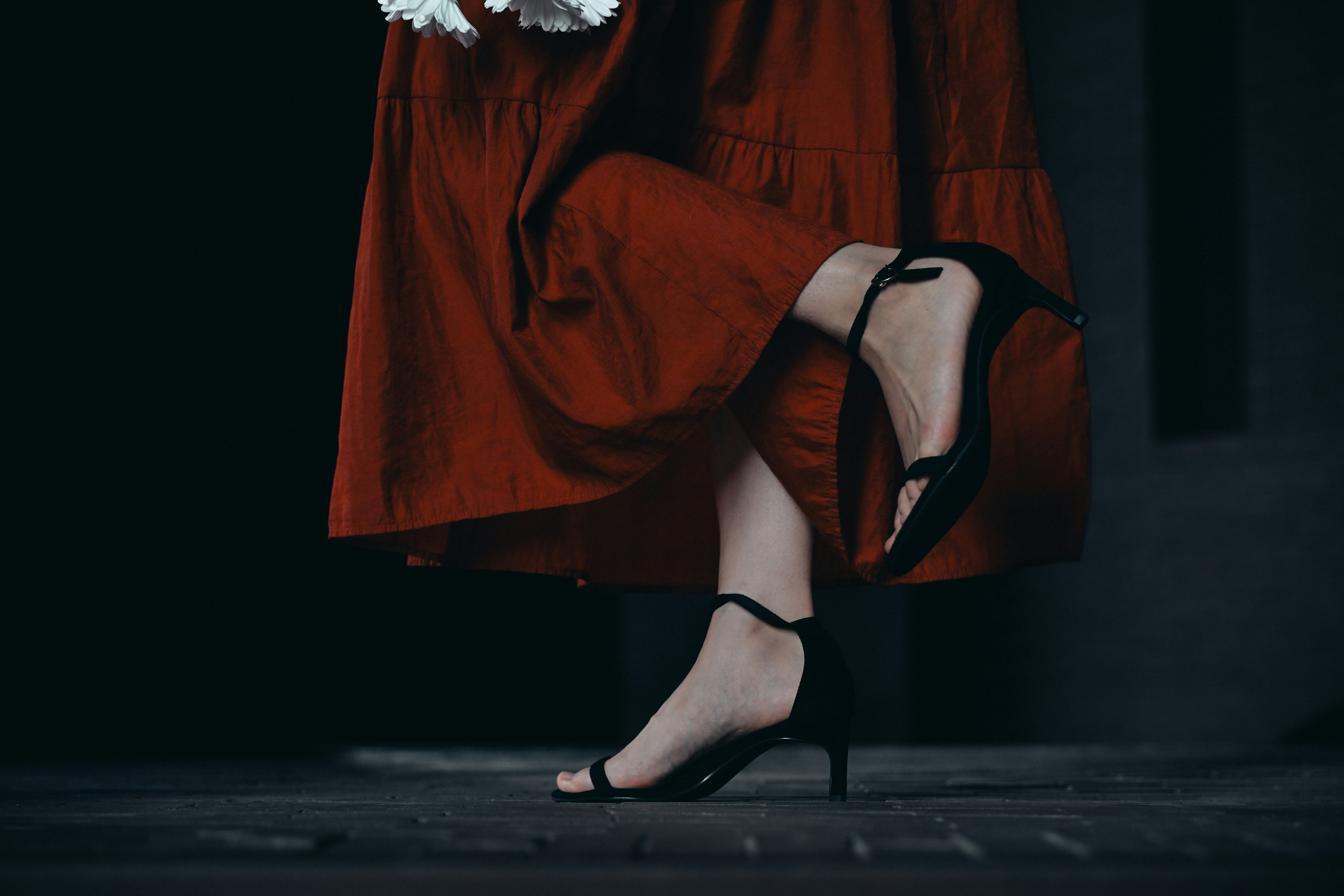 Red-heel poise: a poised stride in the shadowed stage