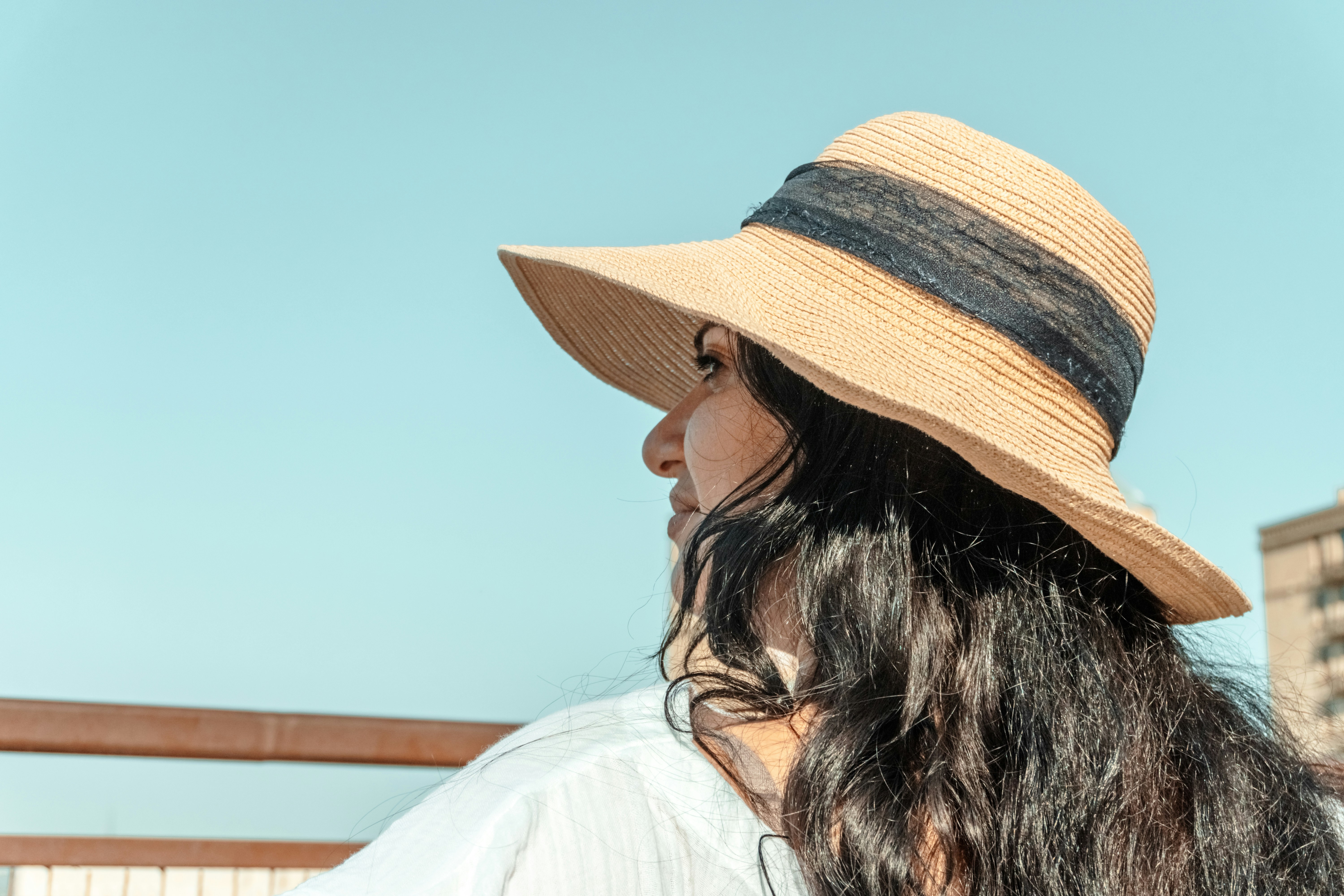 Straw Hat Silhouette: A Relaxed Portrait in Sunlit Calm