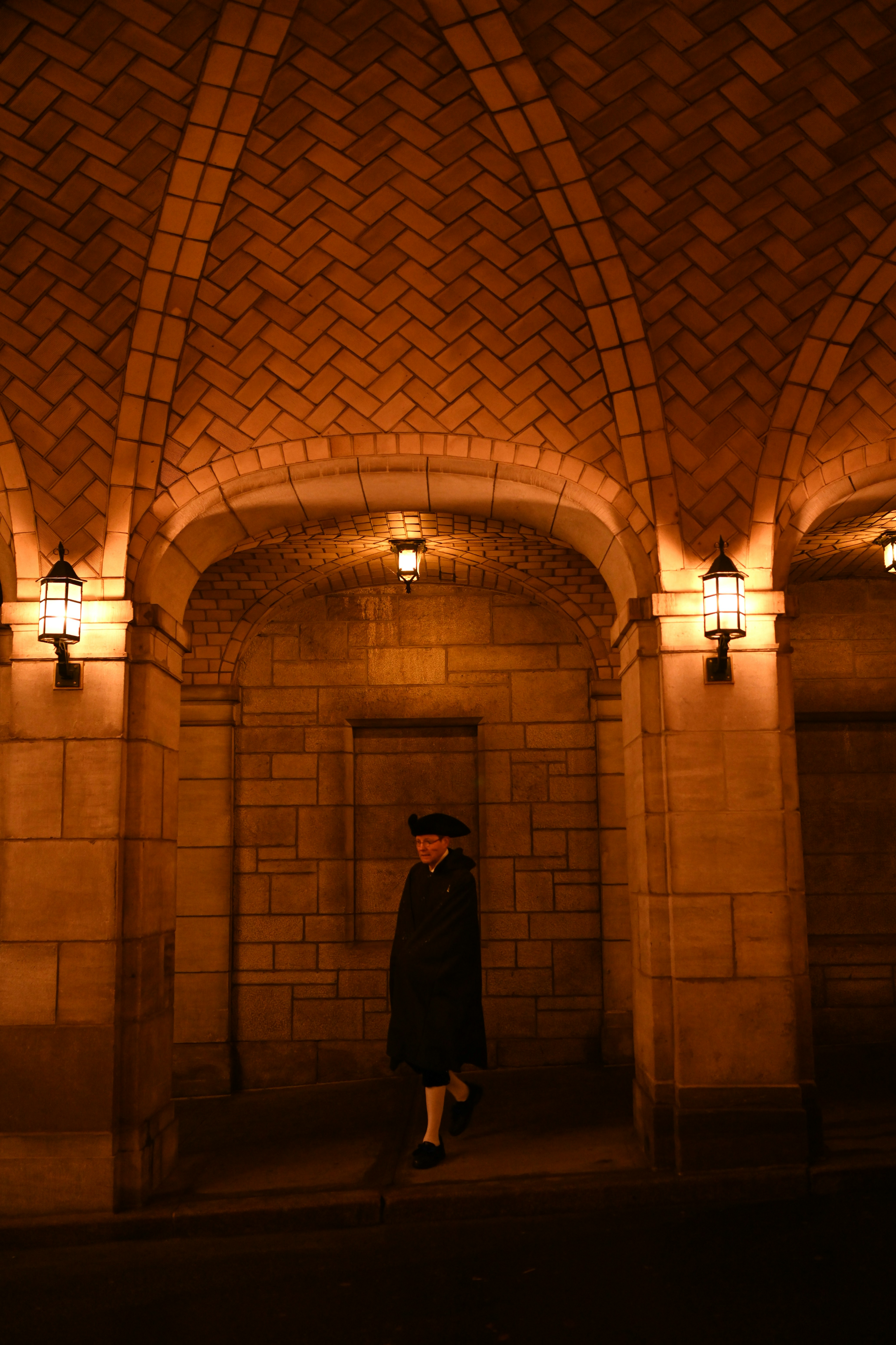 Night Archway: A solitary figure in amber-lit alcove