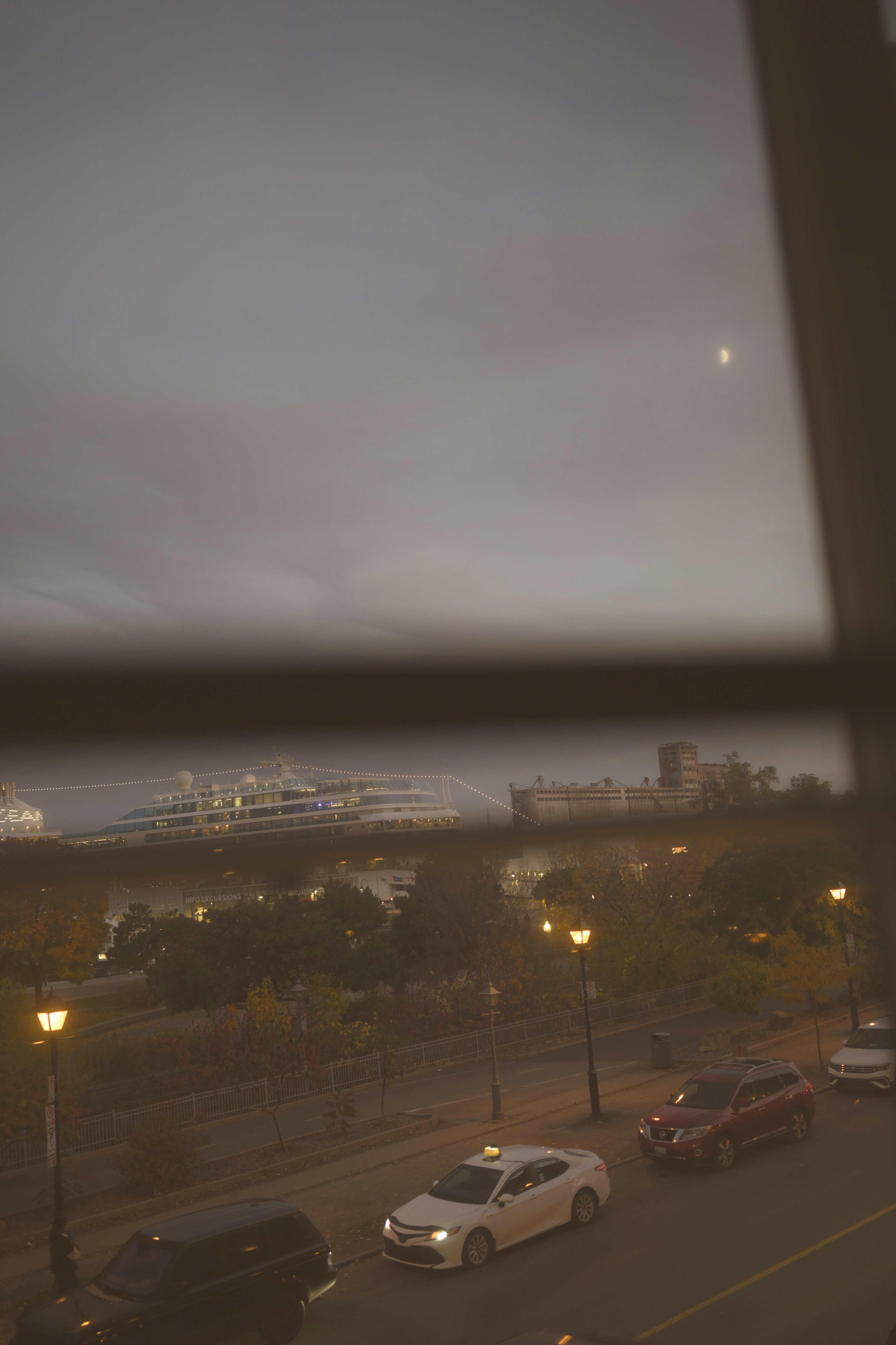 Streetlights, Moving Traffic, and a Distant Waterfront Vista Through a Window