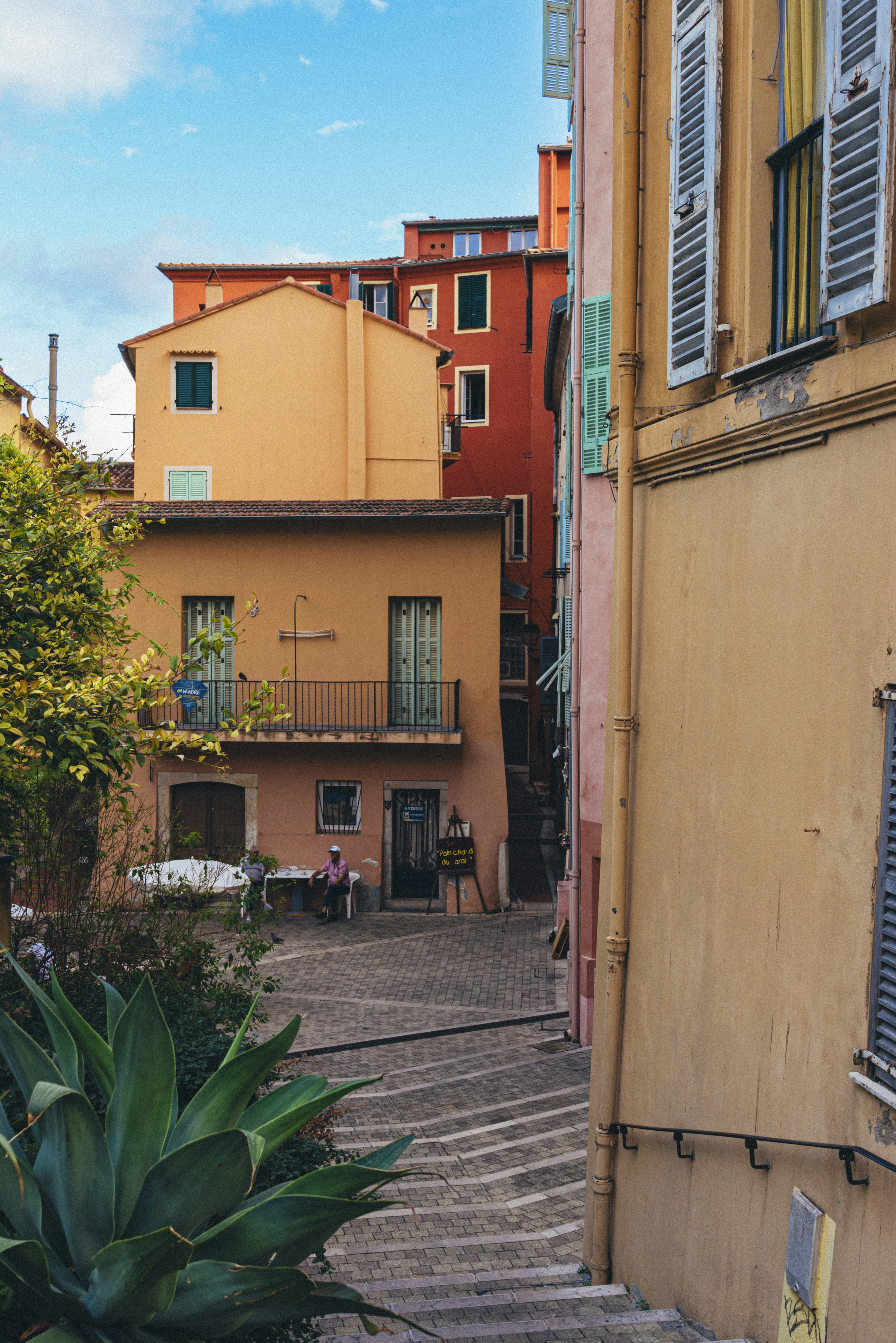 Tuscan Passage: Colorful facades rise along a narrow sunlit alley