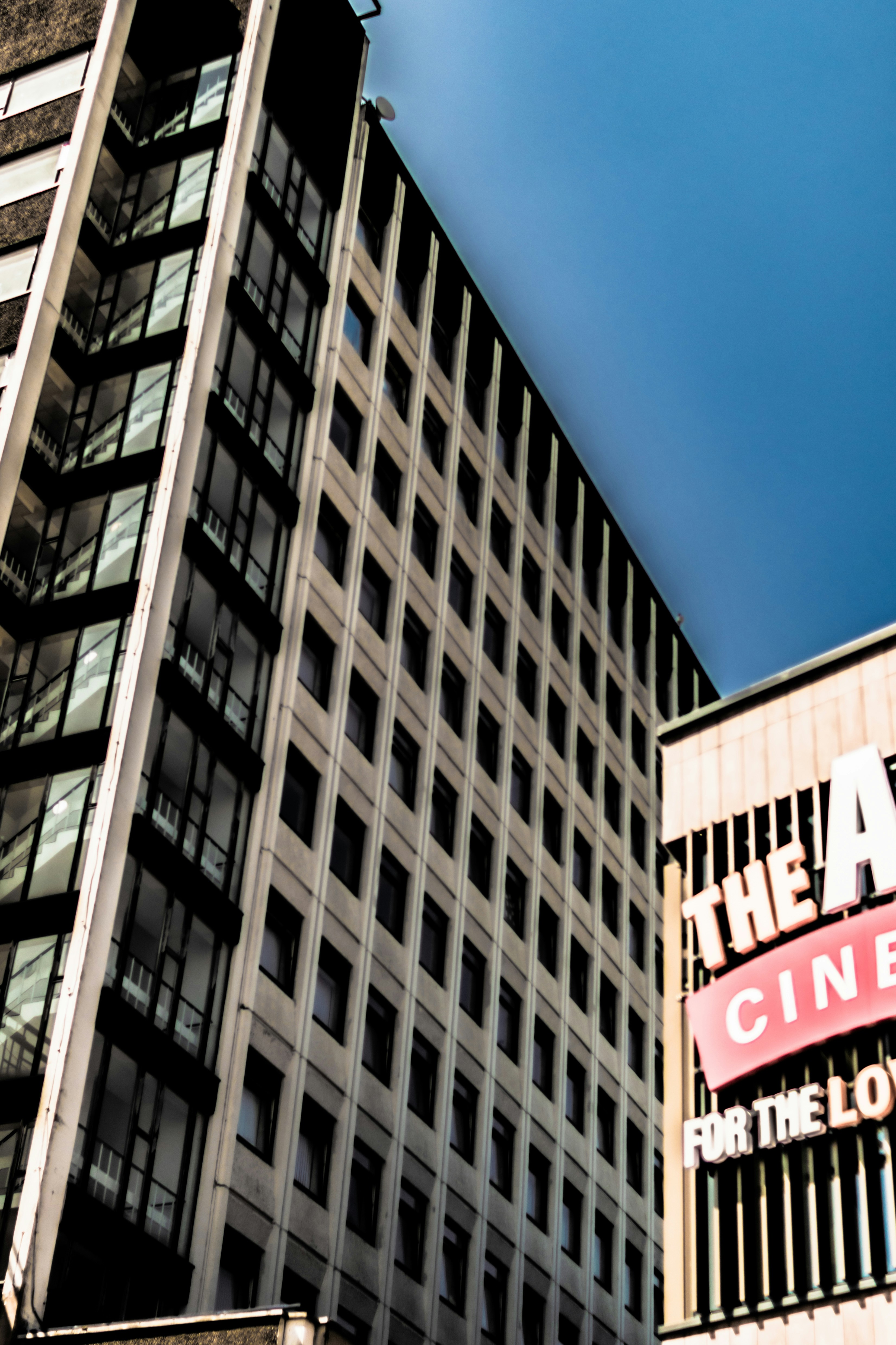 Urban Facade Angled: Glass-and-Grace of a Cine Sign
