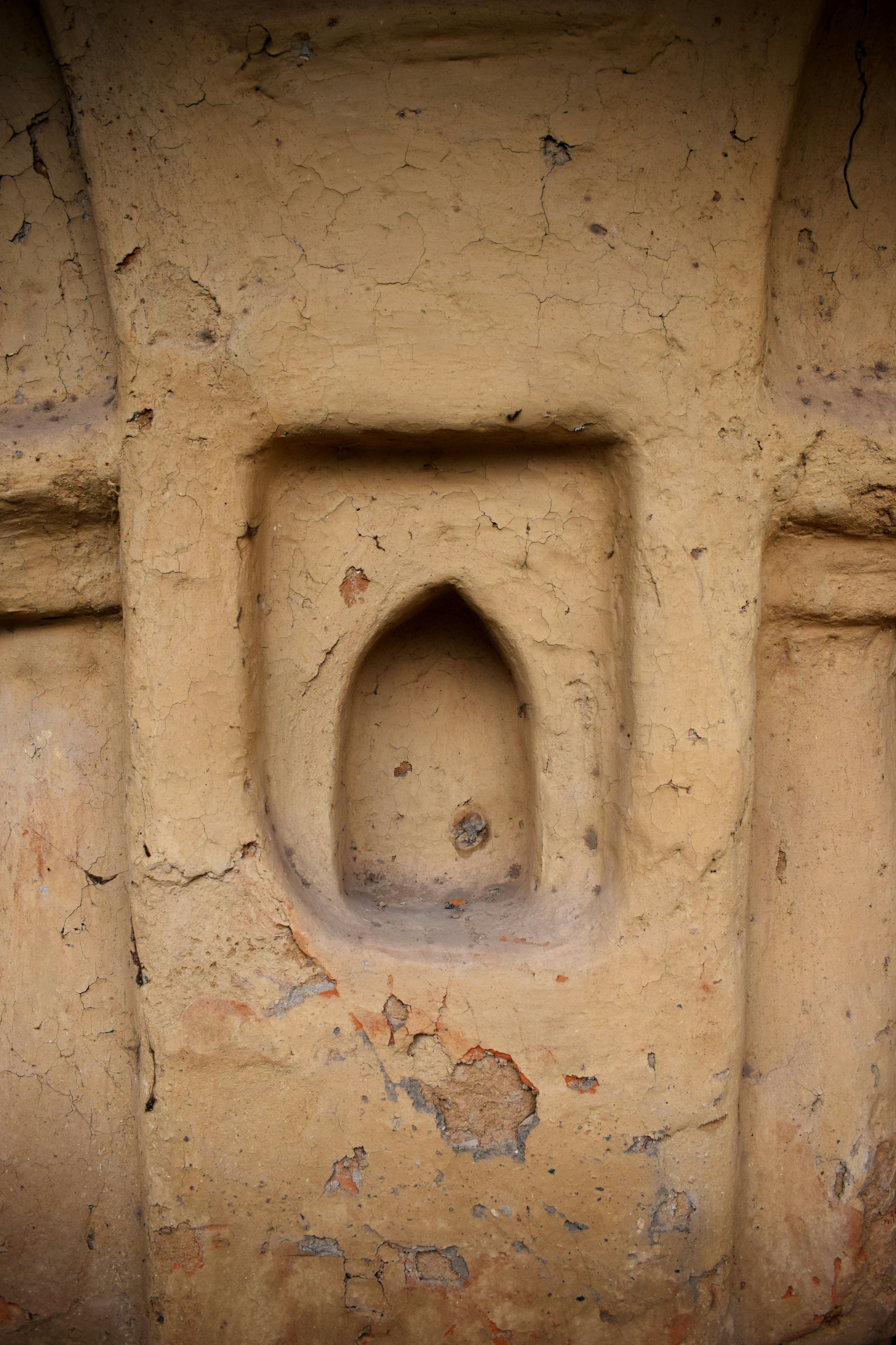 Sandstone Niche: Weathered architectural heart etched in earth-toned walls