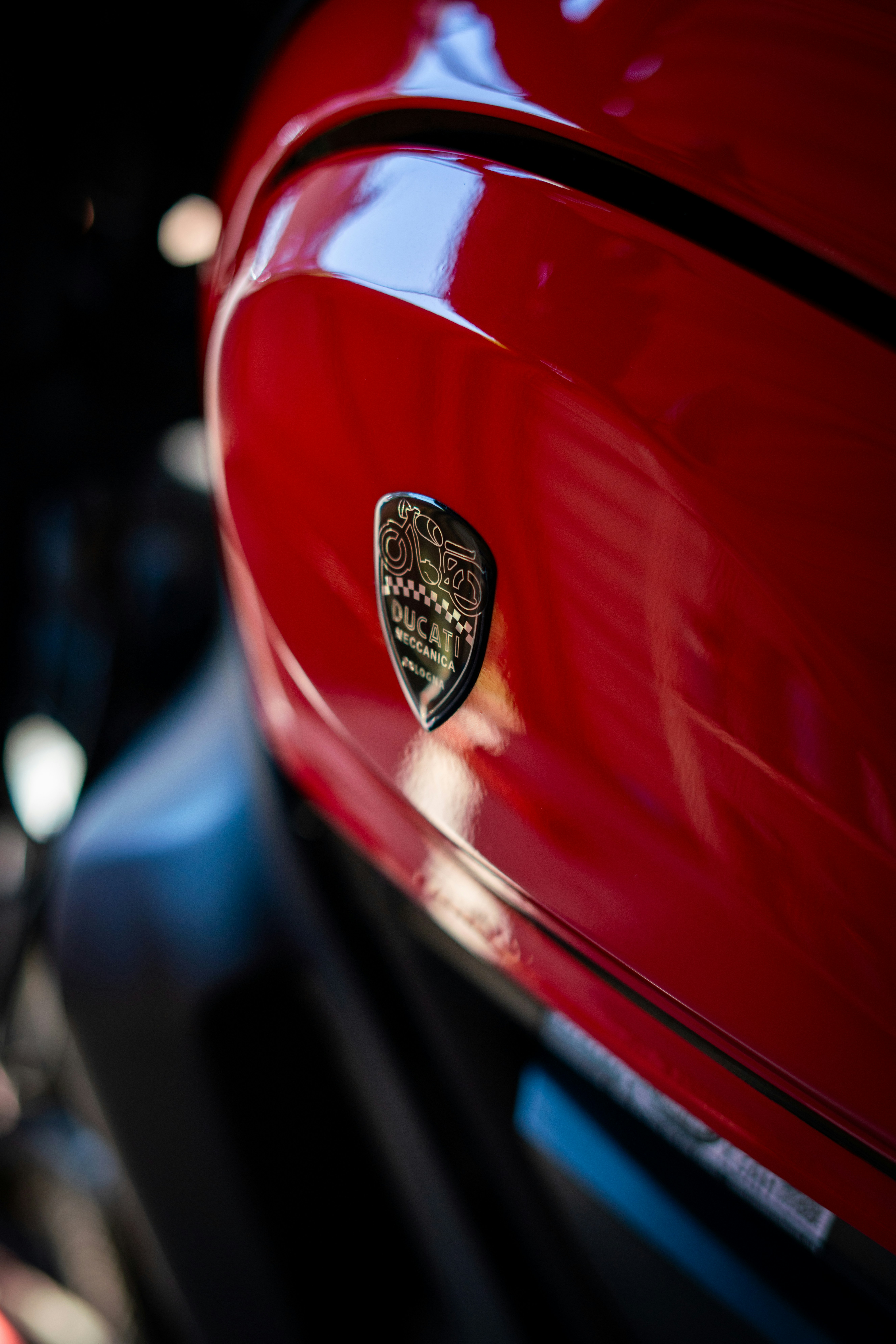 Crimson Curve: Ducati Emblem Reflected on a Glossy Red Surface