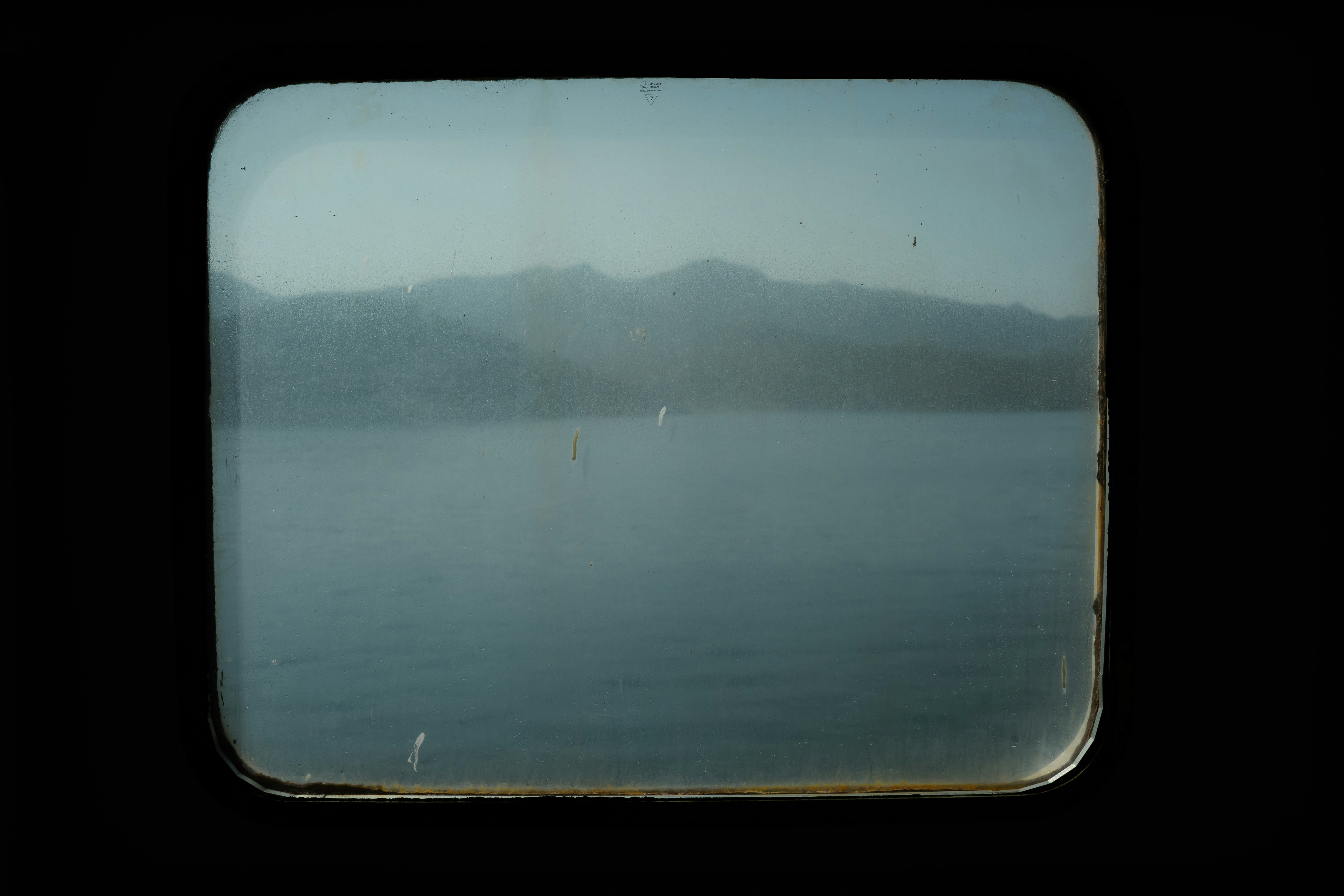Sea of Glass: Distant Mountains through a Window