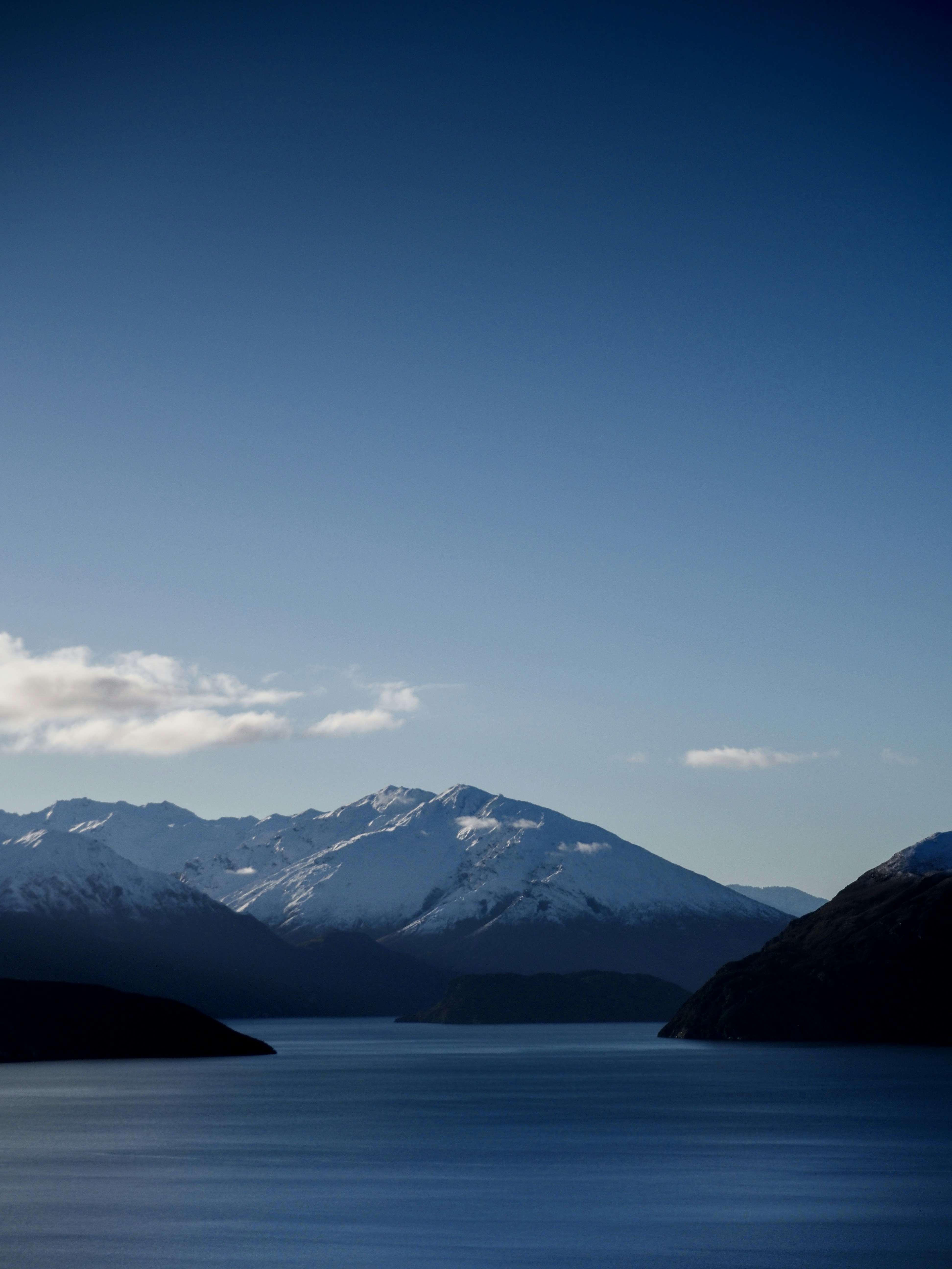 Serene fjord under a quiet, cobalt sky