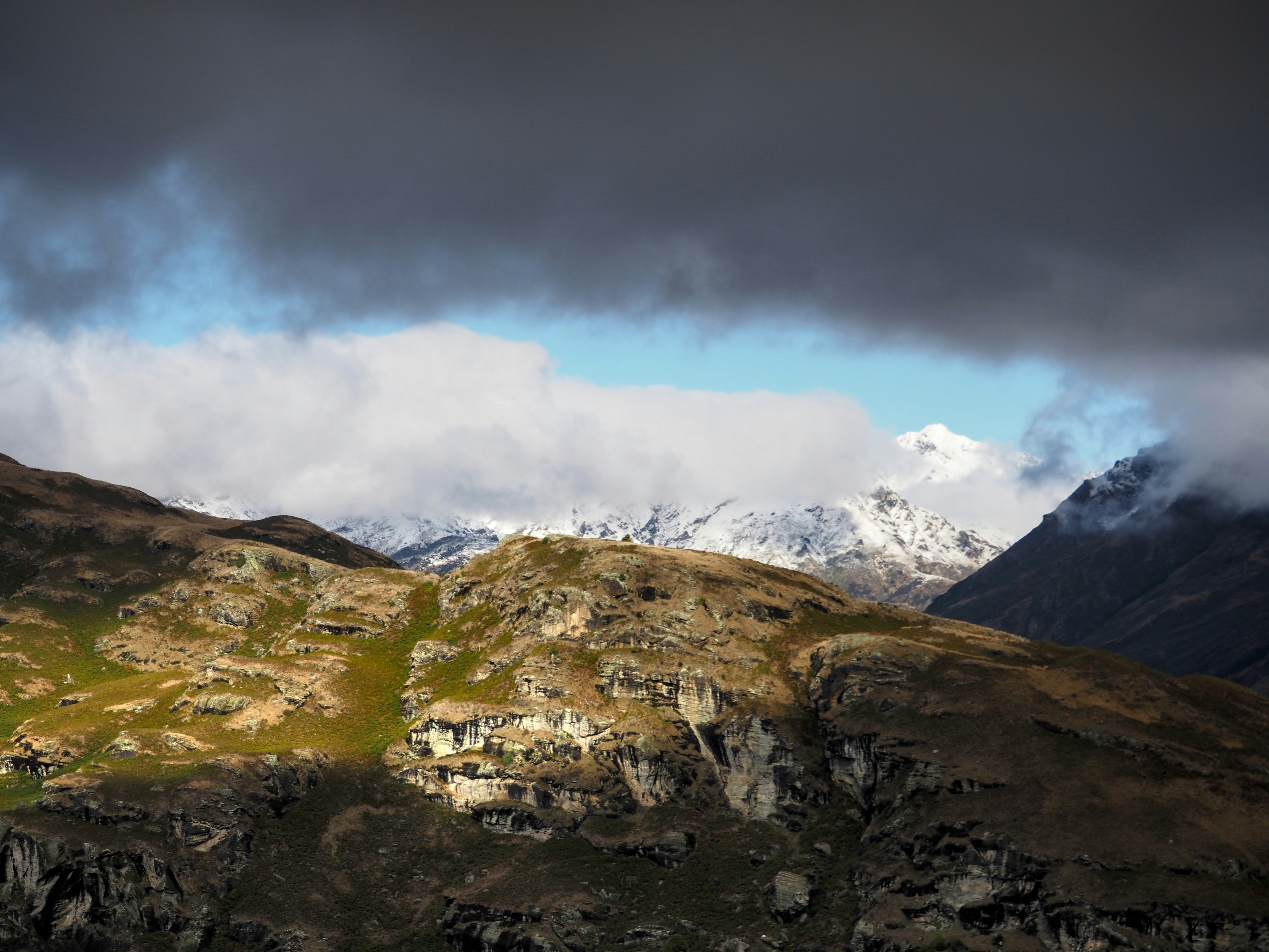 Sunlit Ridge Beneath a Looming Sky