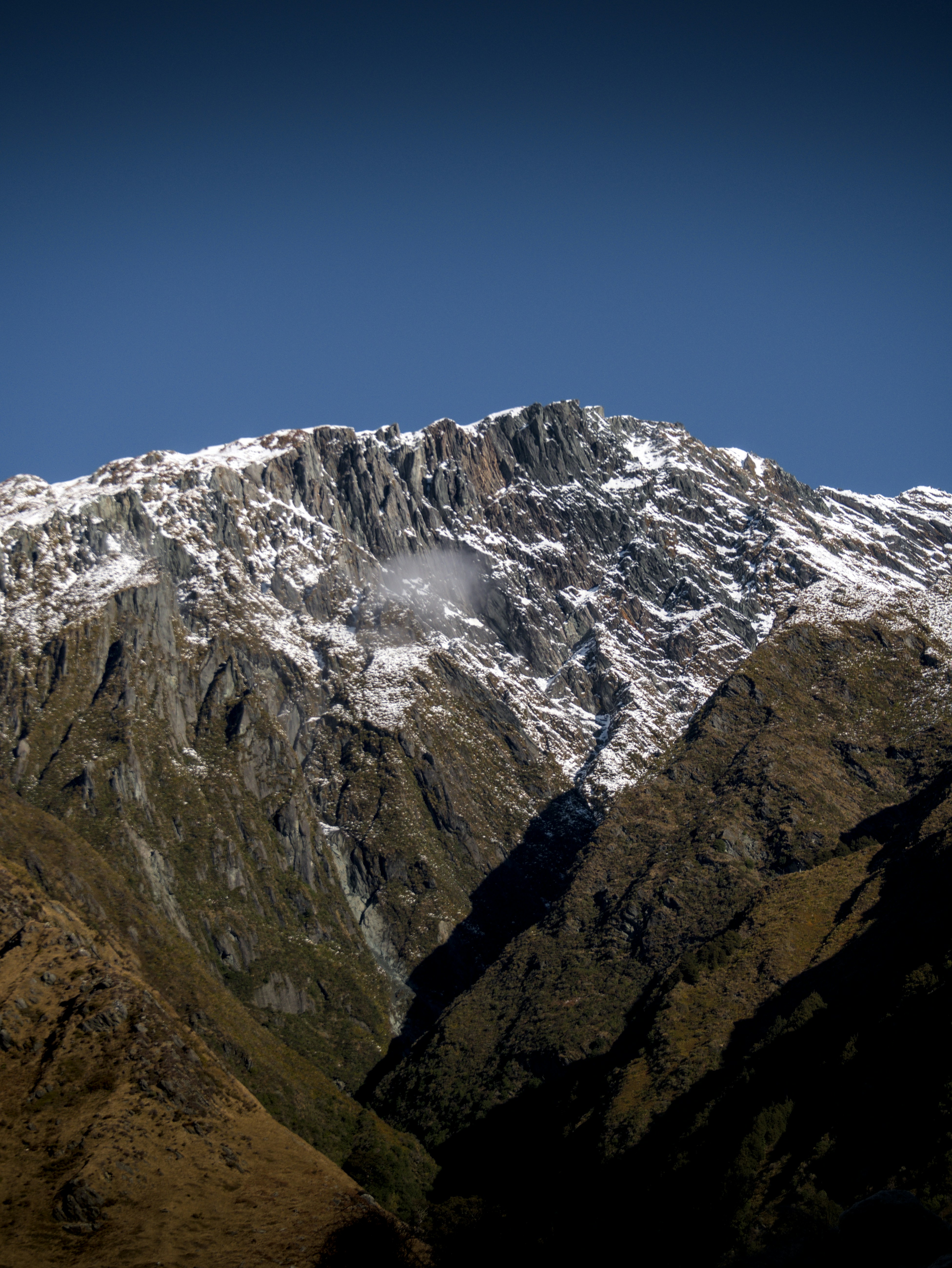 Snow-kissed Crown: A Jagged Alpine Ridge Under Clear Blue Sky