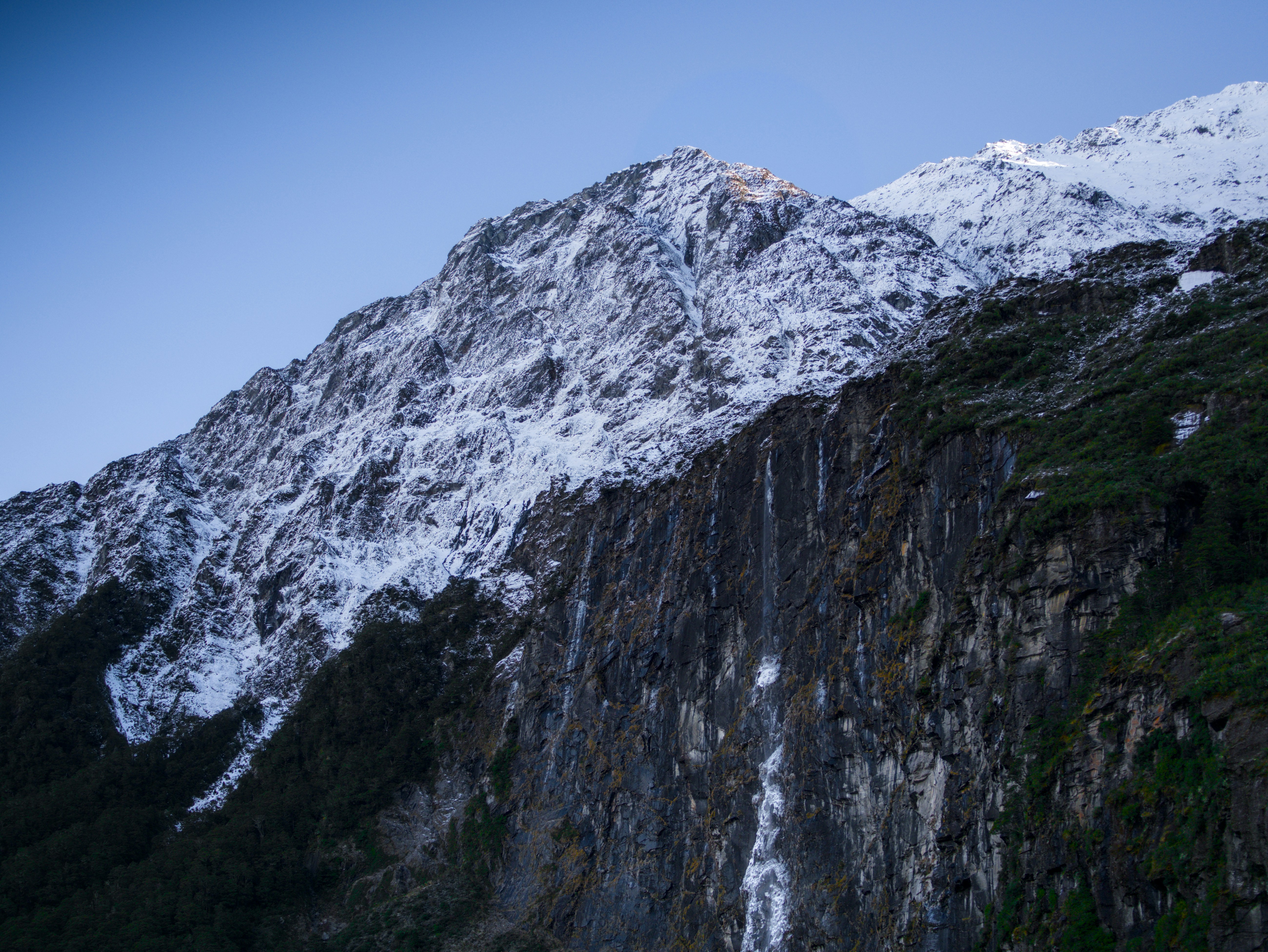 Snow-kissed cliff edge under a crisp blue sky