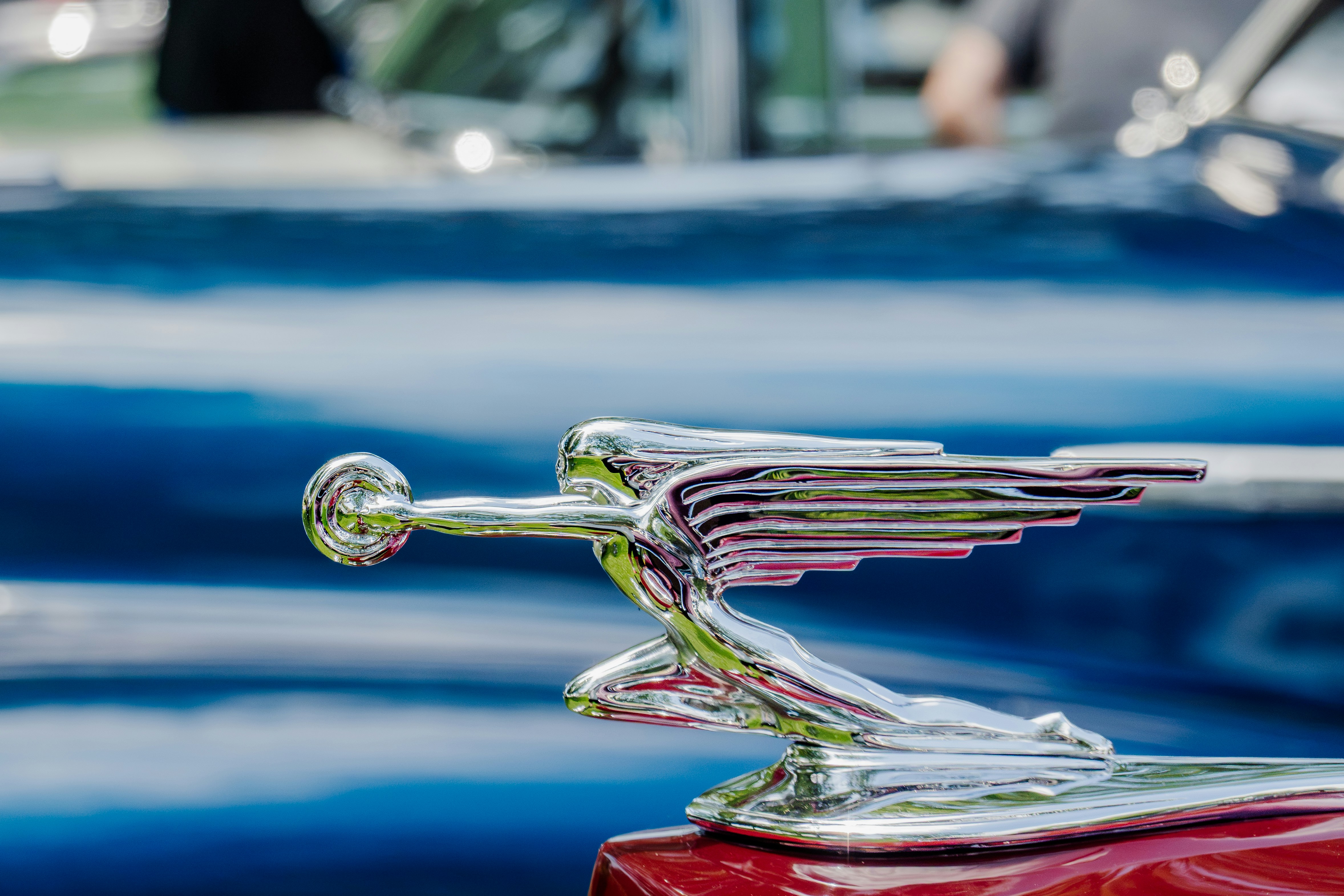 Gleaming Wings: Chrome Hood Ornament on a Classic Car