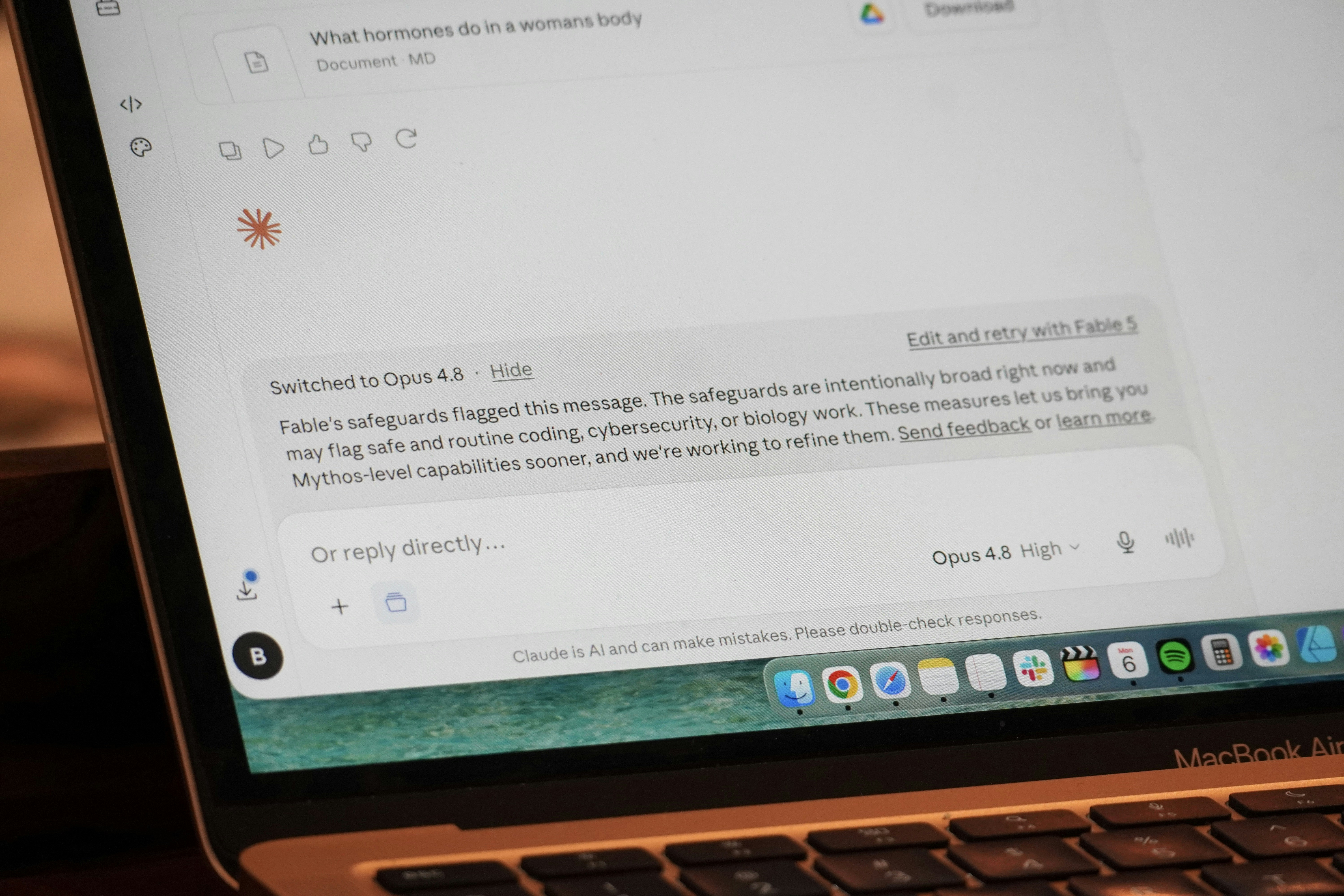 Claude AI displaying a "Switched to Opus 4.8" notice on a laptop screen, after Fable 5's safeguards flagged a routine question about hormones. Anthropic's message concedes the safeguards are intentionally broad and may flag safe coding, cybersecurity, or biology work. Shot in July 2026, weeks after the US Commerce Department's export-control directive took Fable 5 and Mythos 5 offline worldwide.