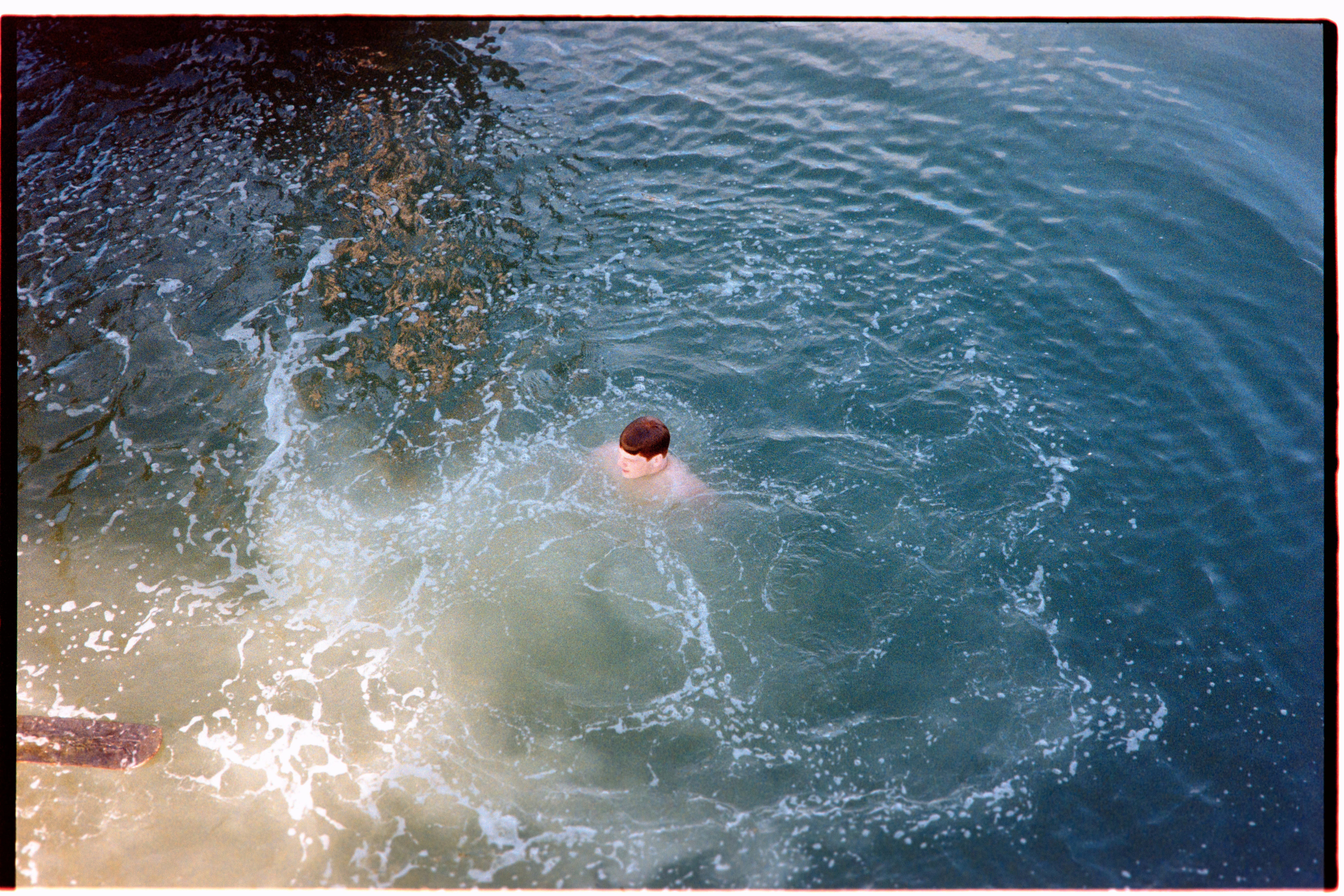 Centered Dive: A lone swimmer cuts through turquoise currents from above