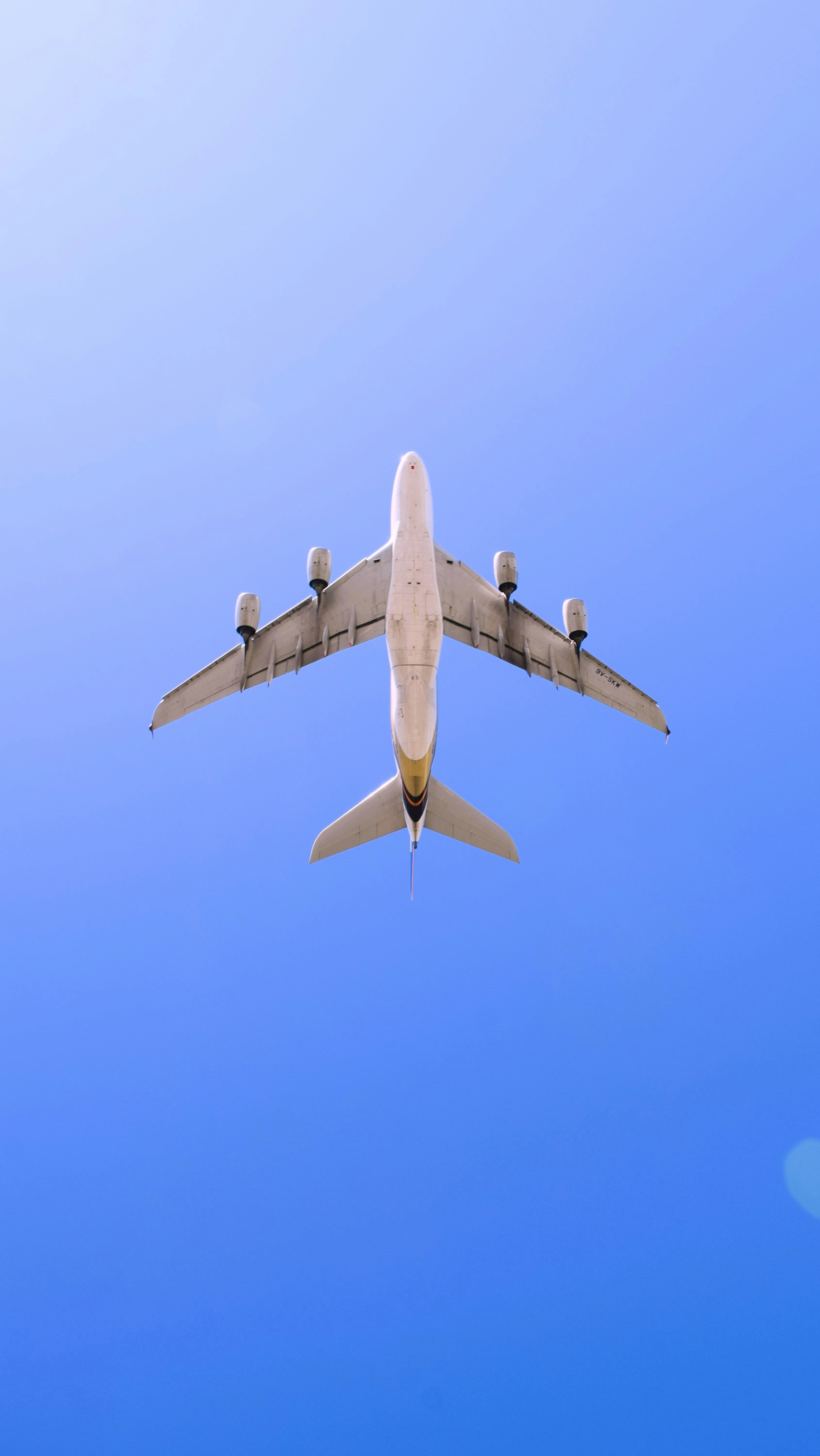 Nose-First Skyward: A Passenger Jet Moves Across a Clear Blue Canopy
