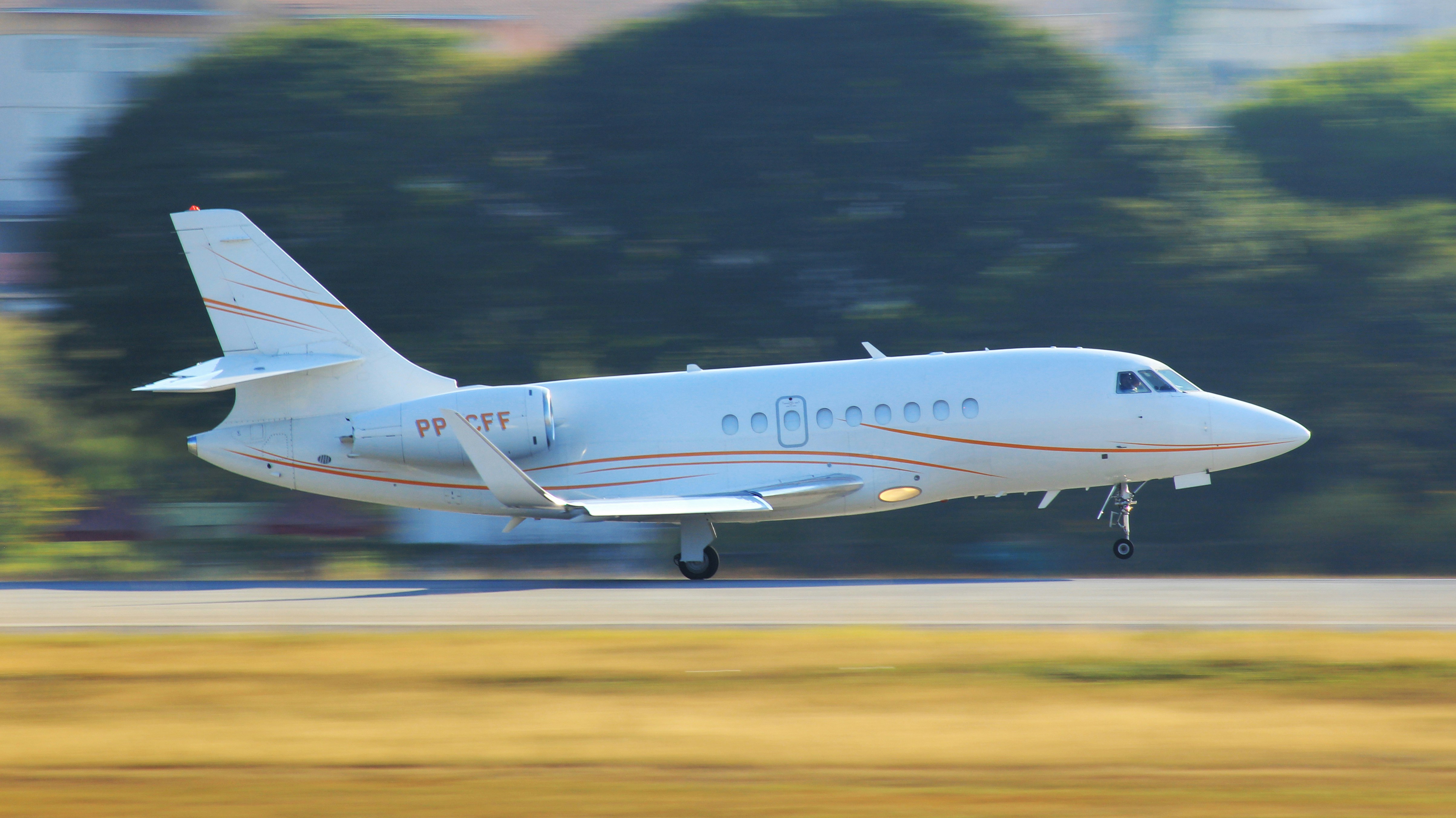Jet in Motion: White Learjet strobes across a sunlit runway