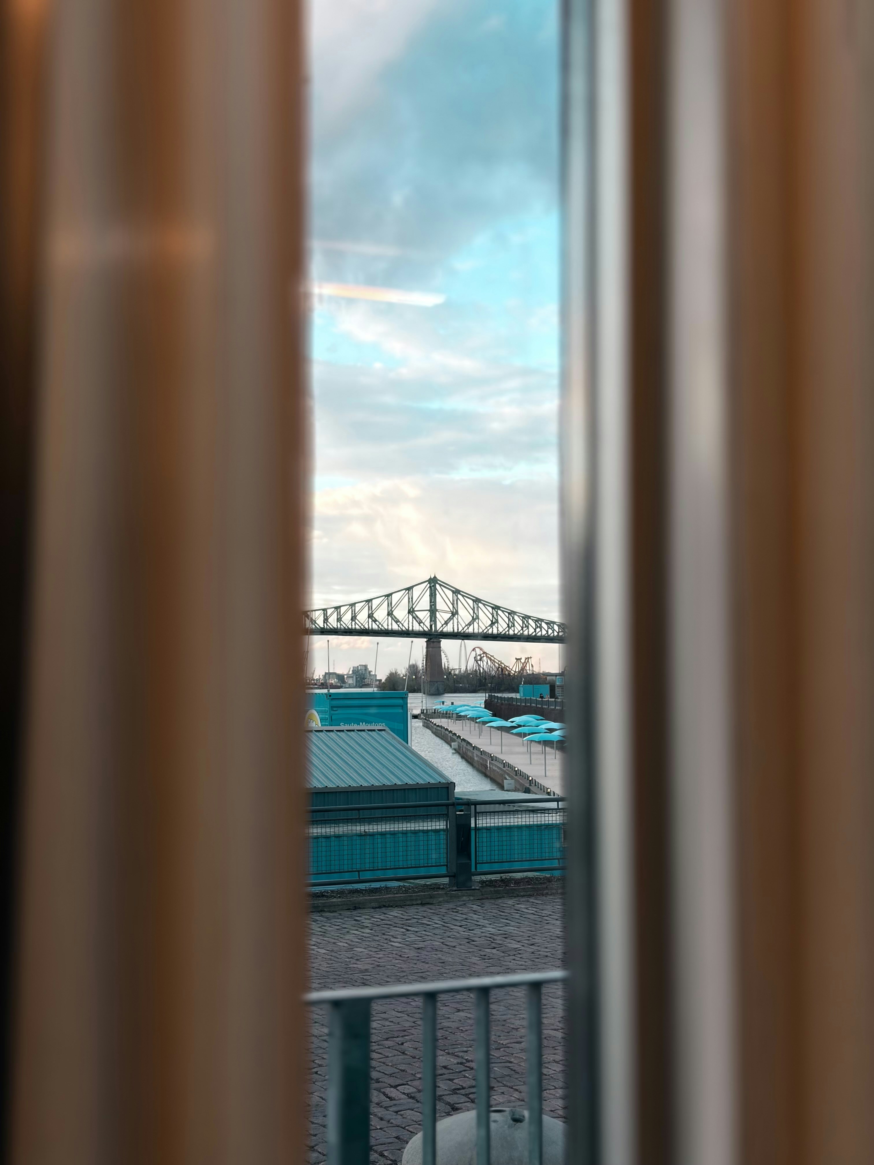 Through the Narrow View: a Harbor Bridge Framed by Curtain Edges