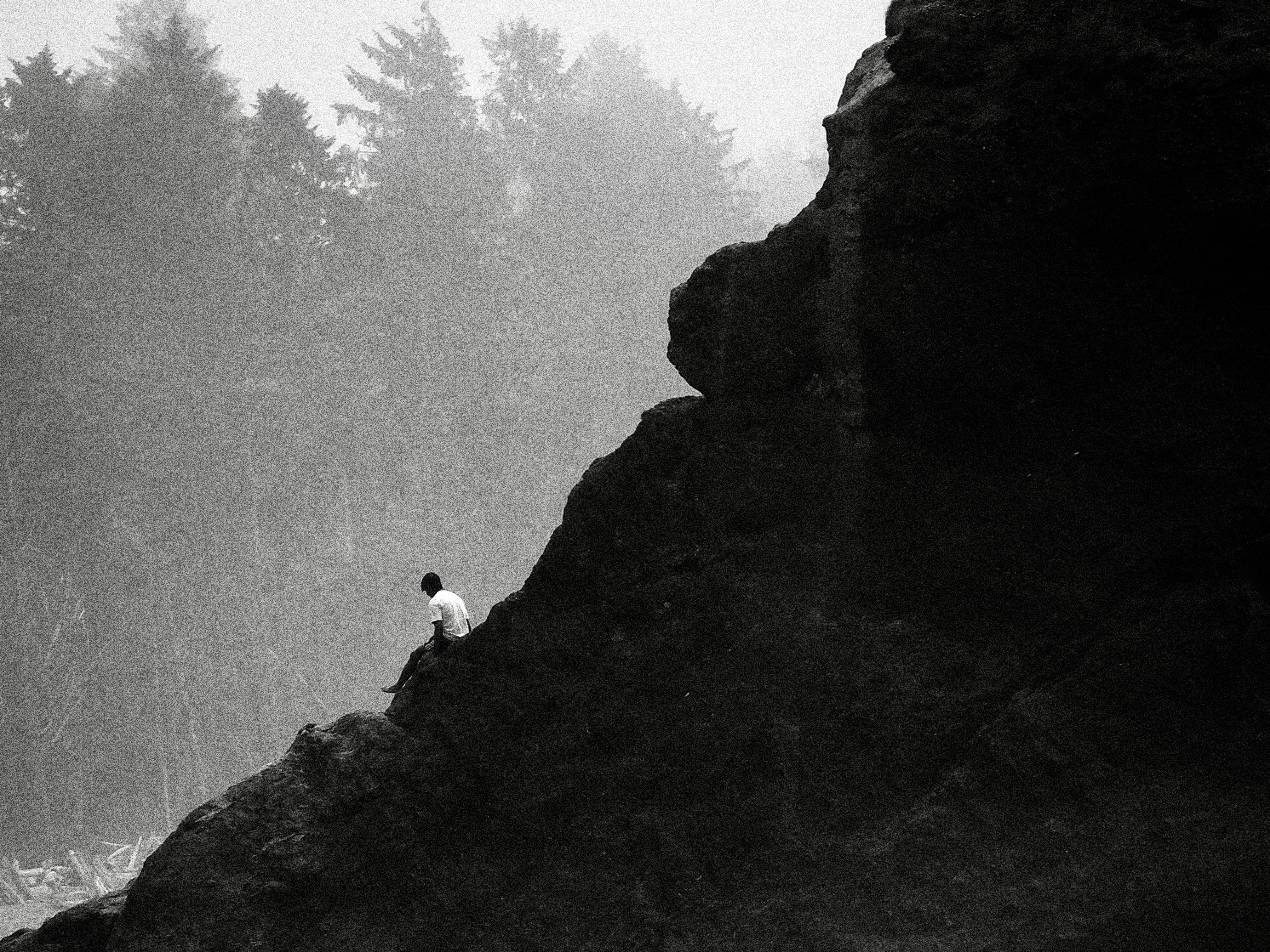 Cliffside Silhouette: A Lone Figure Against the Mountain