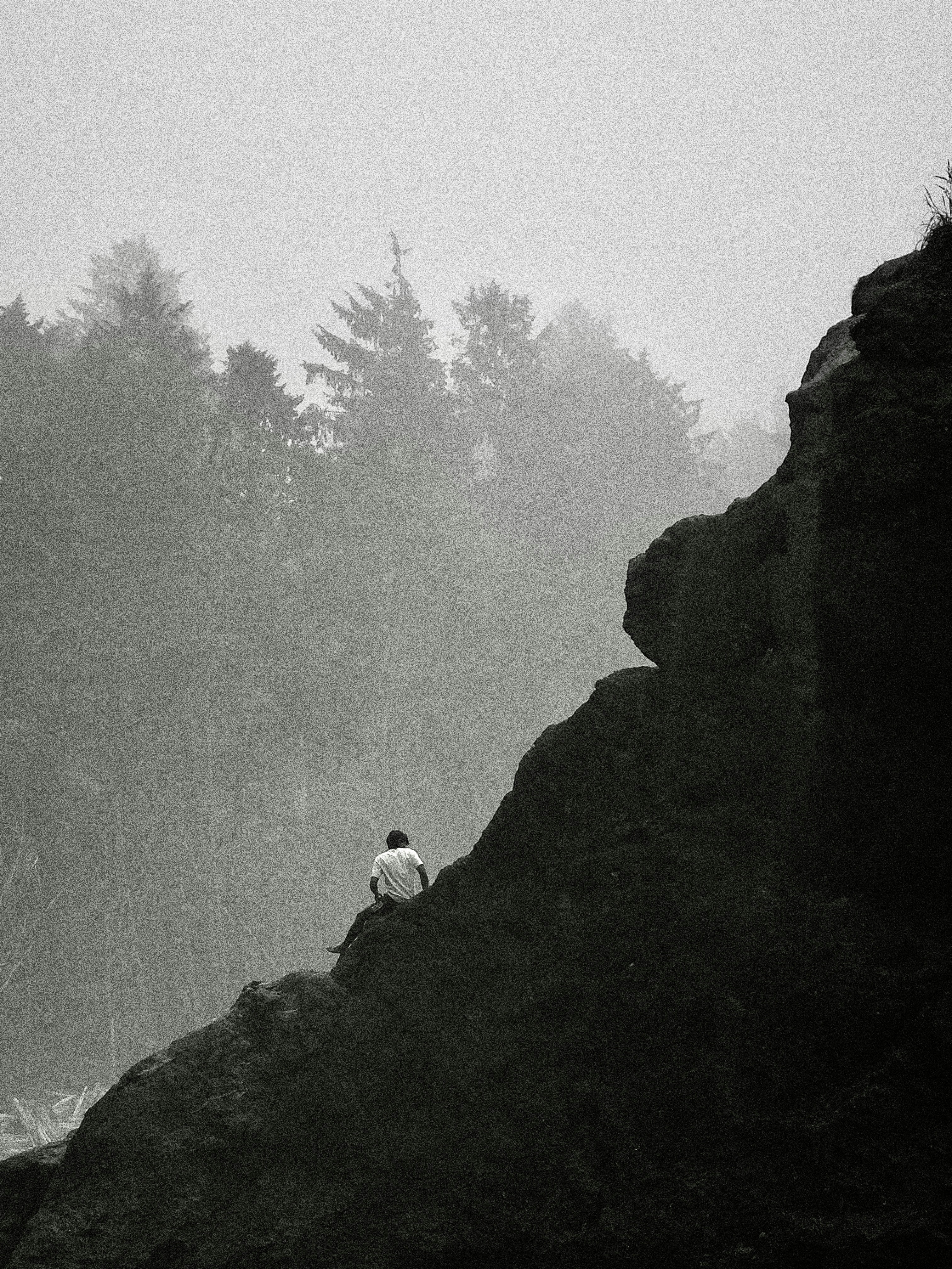 Cliffside Solitude: A Lone Figure on the Dark Ridge