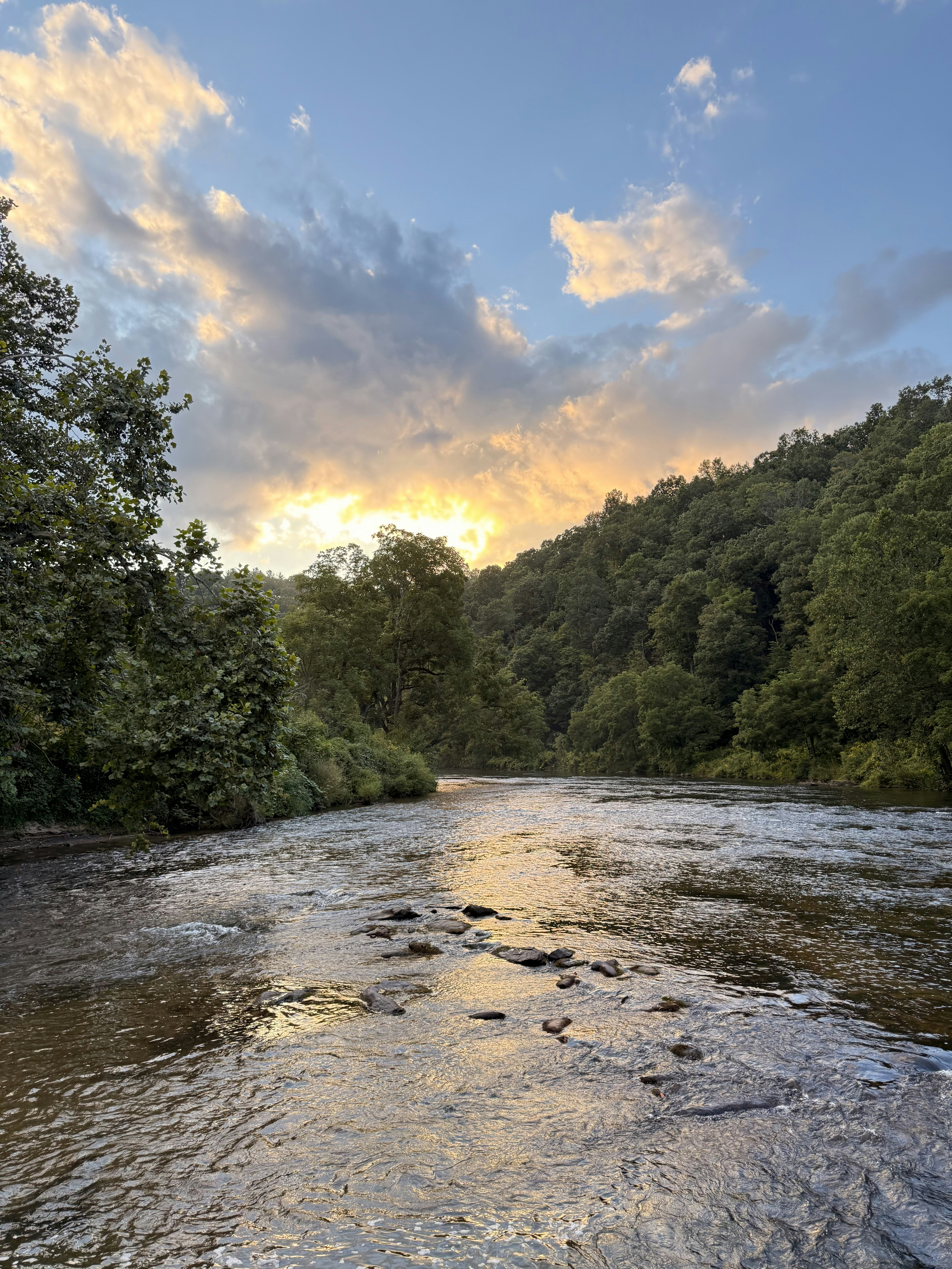 River at Dusk: Golden Clouds Over a Quiet Current
