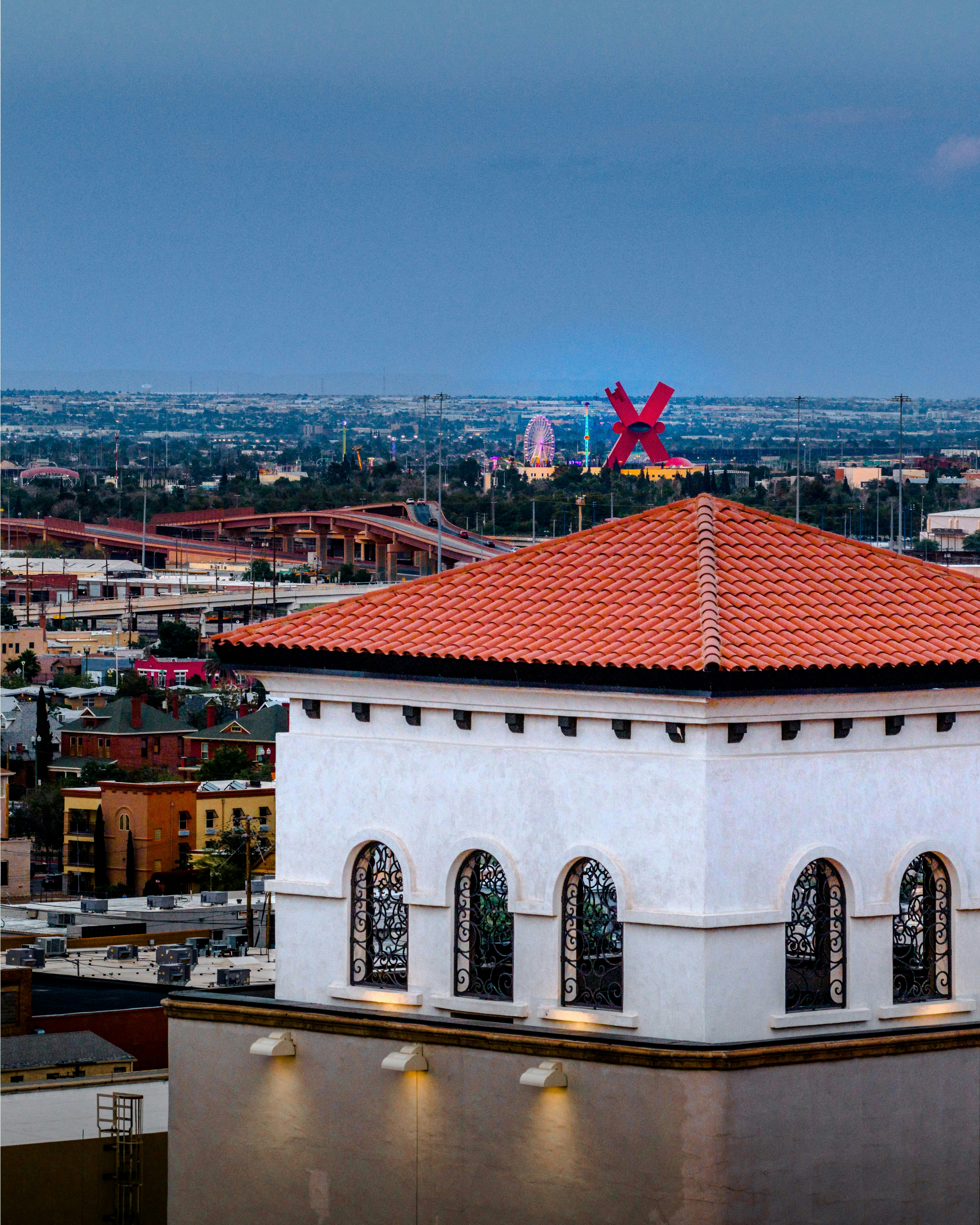 Terracotta Rooflines and a Neon X: A City Silhouette from Above