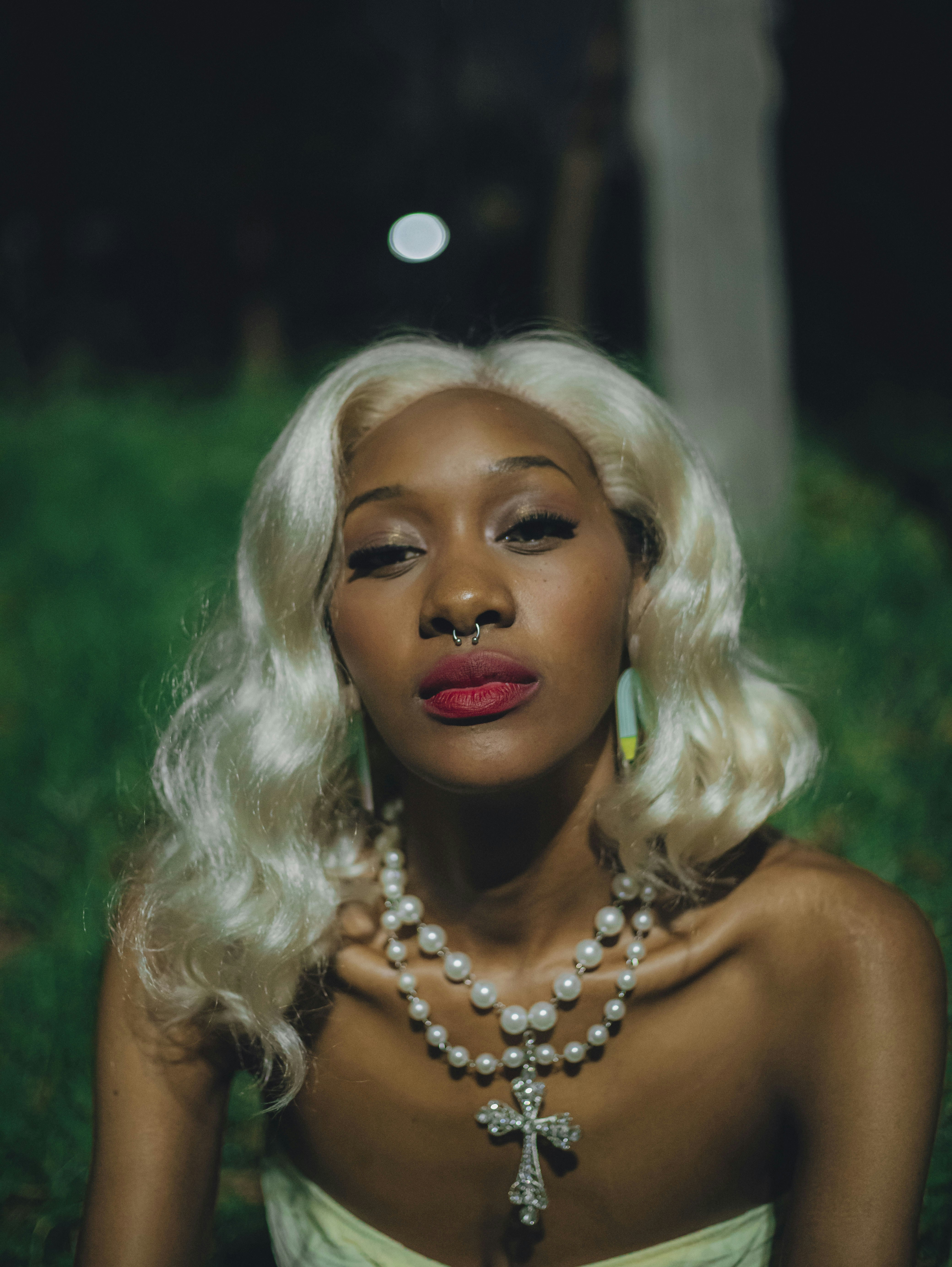 Midnight Radiance: Pearl Necklace and Blond Tresses Under Night Lights