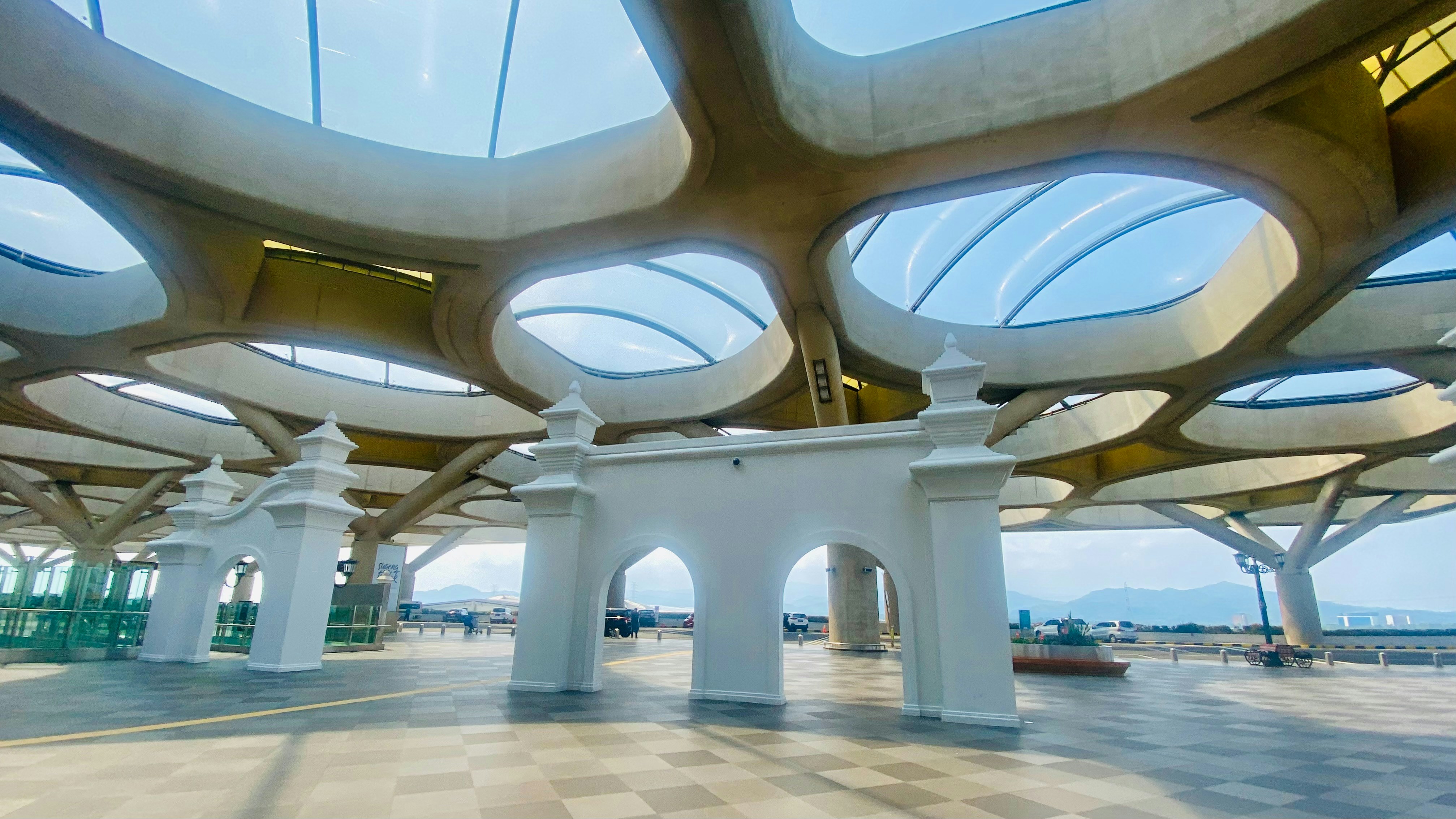 Circular Sky-Openings Over a White Archway Gallery
