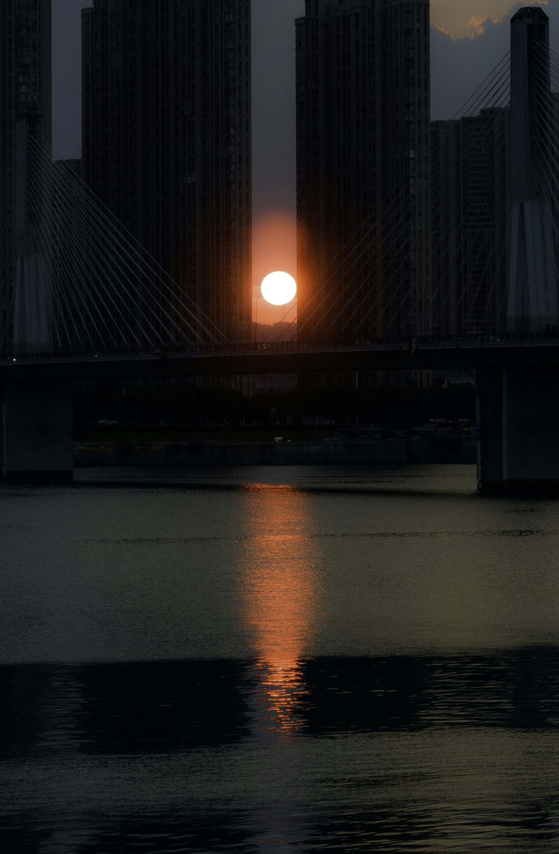 Sunlit centerpiece: sun between towers over a bridge