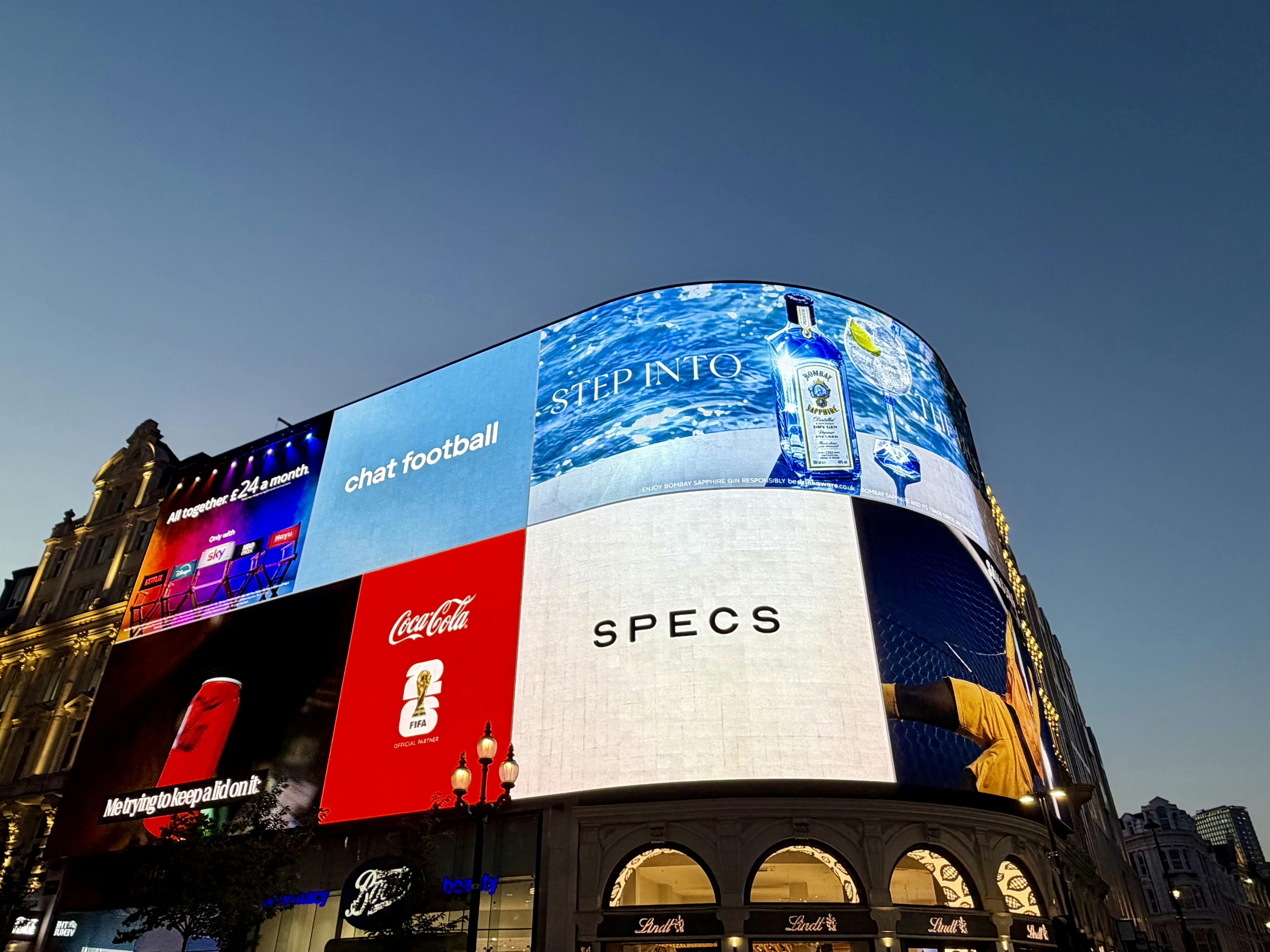 Billboard Mosaic: Neon Grid Adverts Crown a Curved landmark