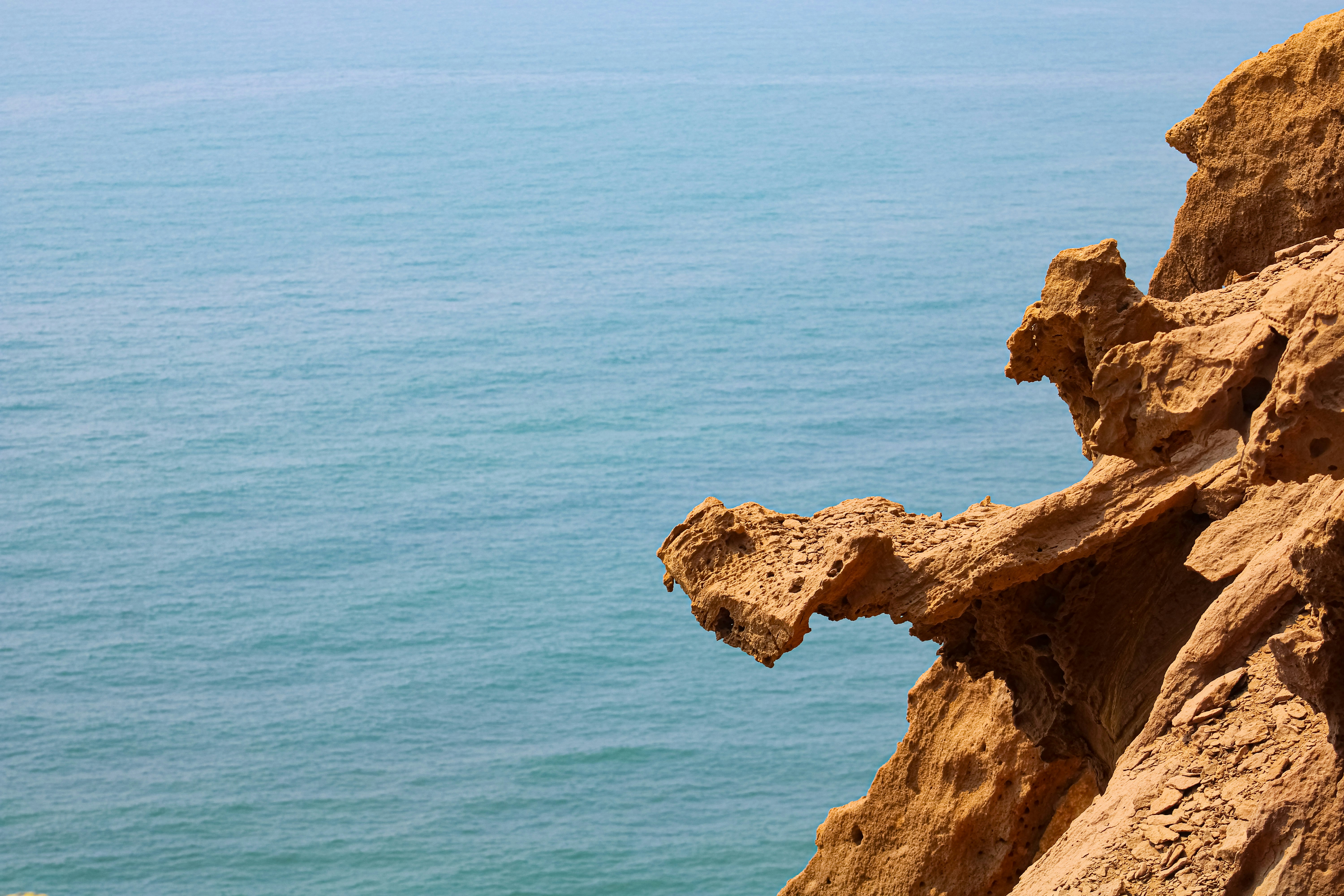 Deserted coastal cliff sculpted by wind against a calm sea