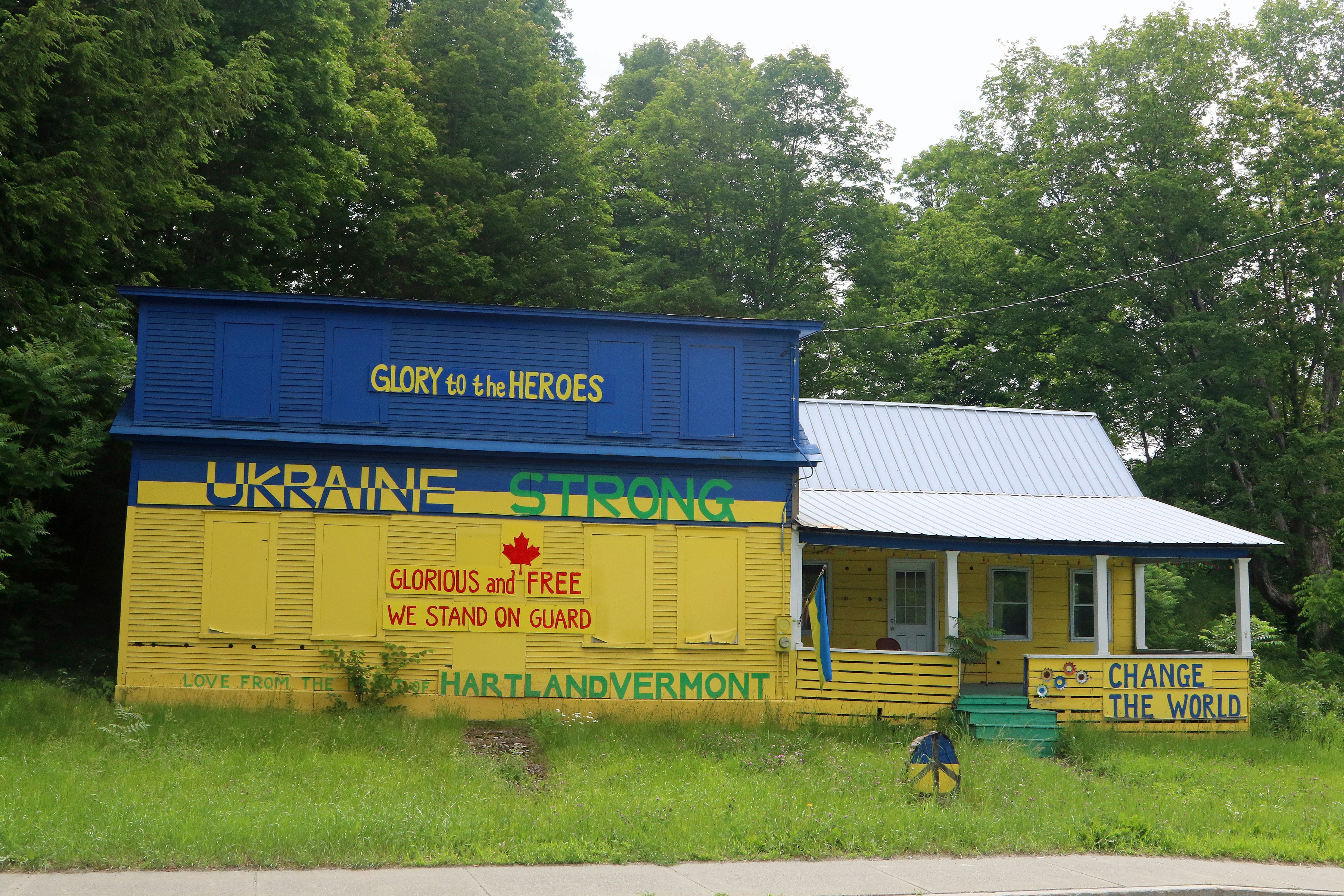 Colorful Ukrainian-flagged cabin shouting messages of unity on a rural Vermont road