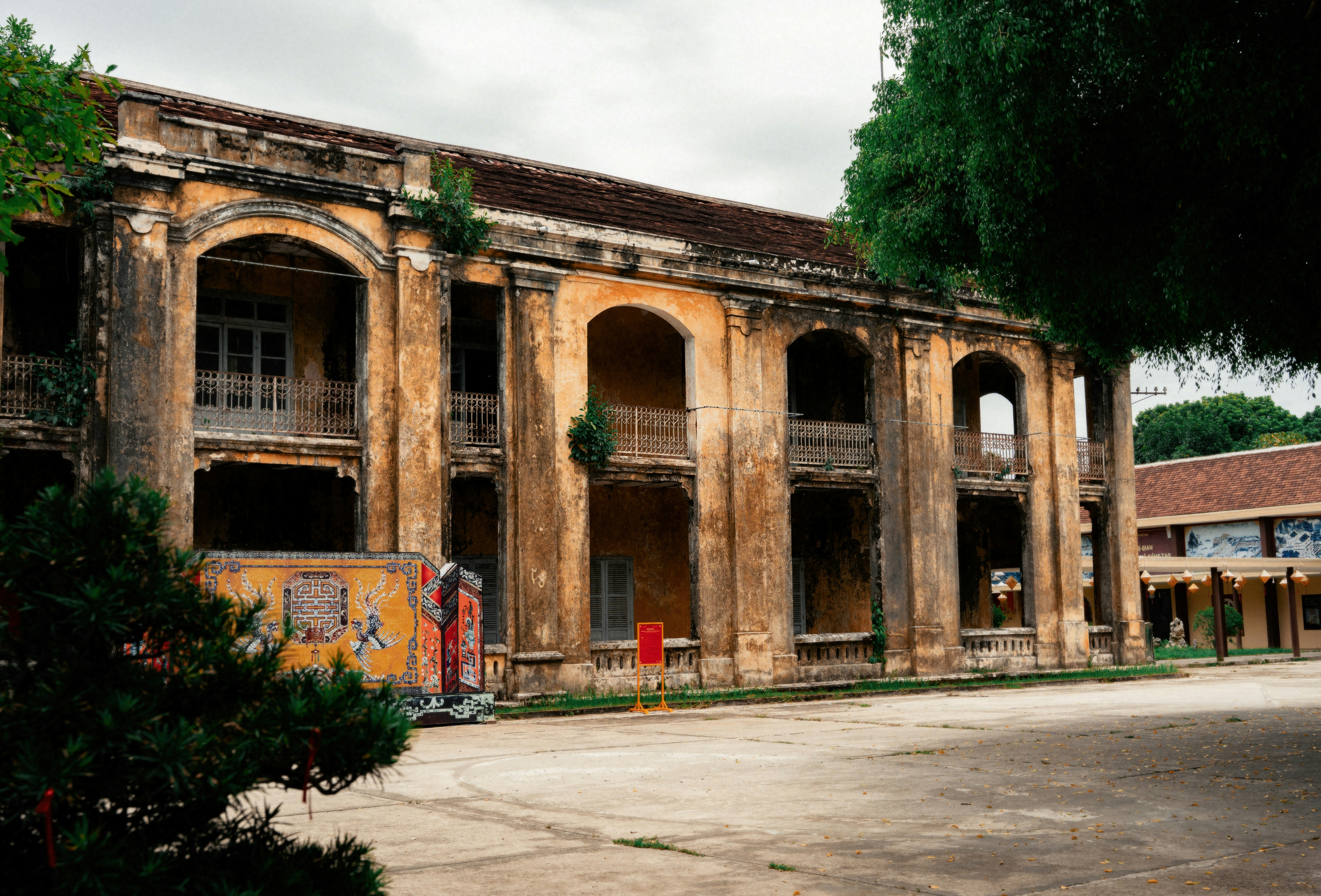 Sunlit Facade of a Deteriorating colonial building in an empty courtyard