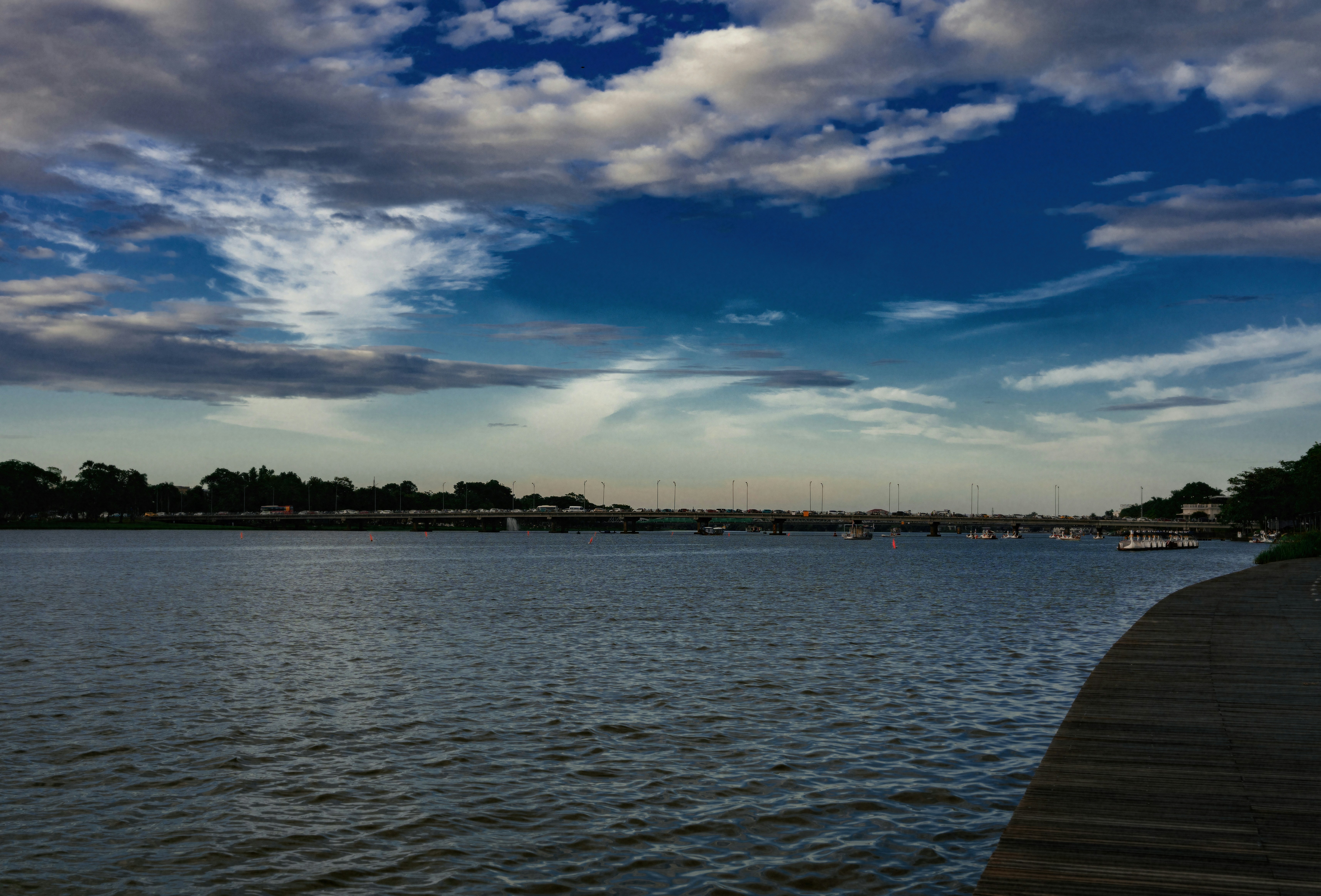 Horizon Harbor: Boats at Dusk Along a Curved Boardwalk