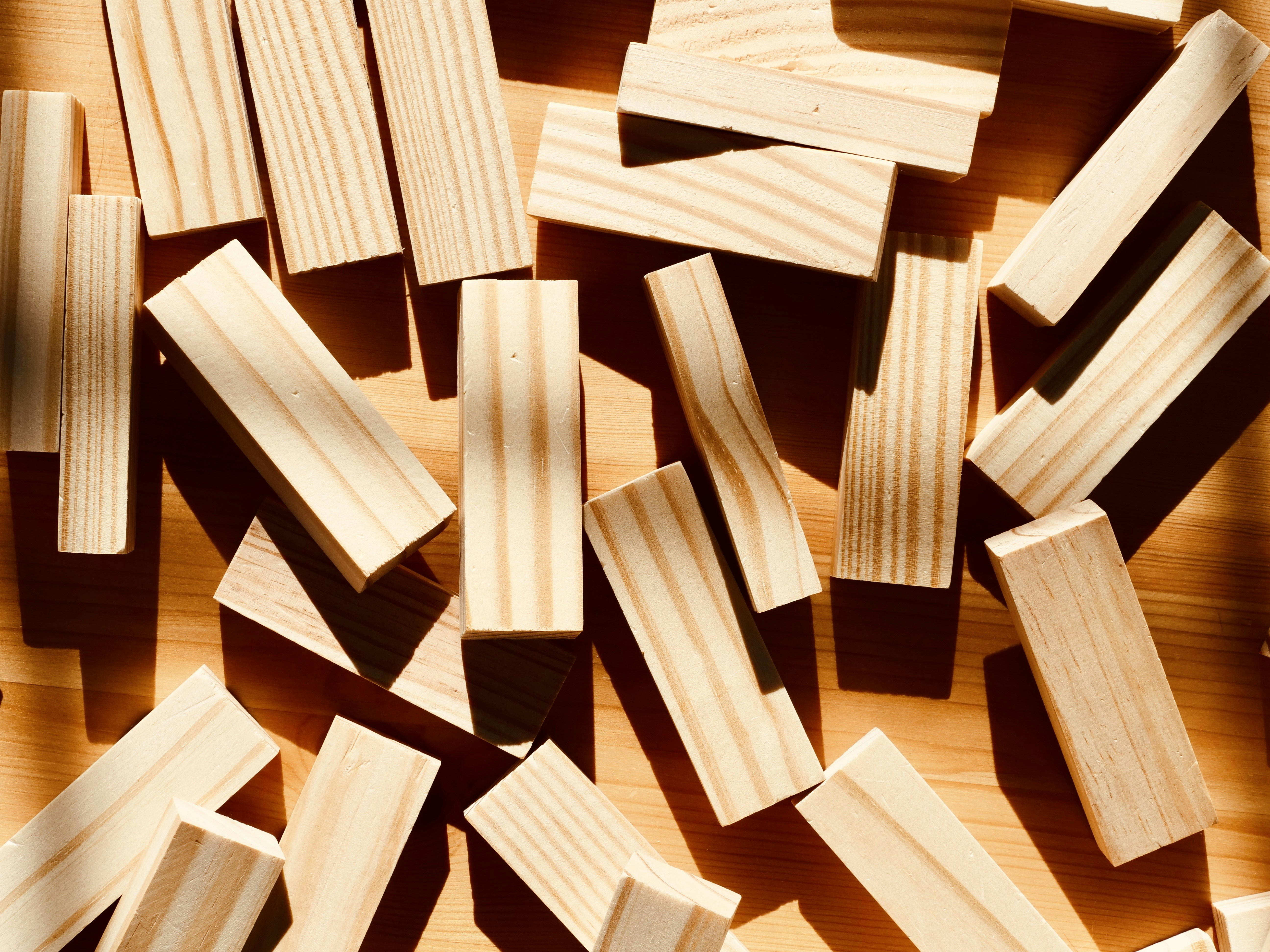 Patchwork of Pine: A Playful Scatter of Wood Blocks in Sunlit Warmth