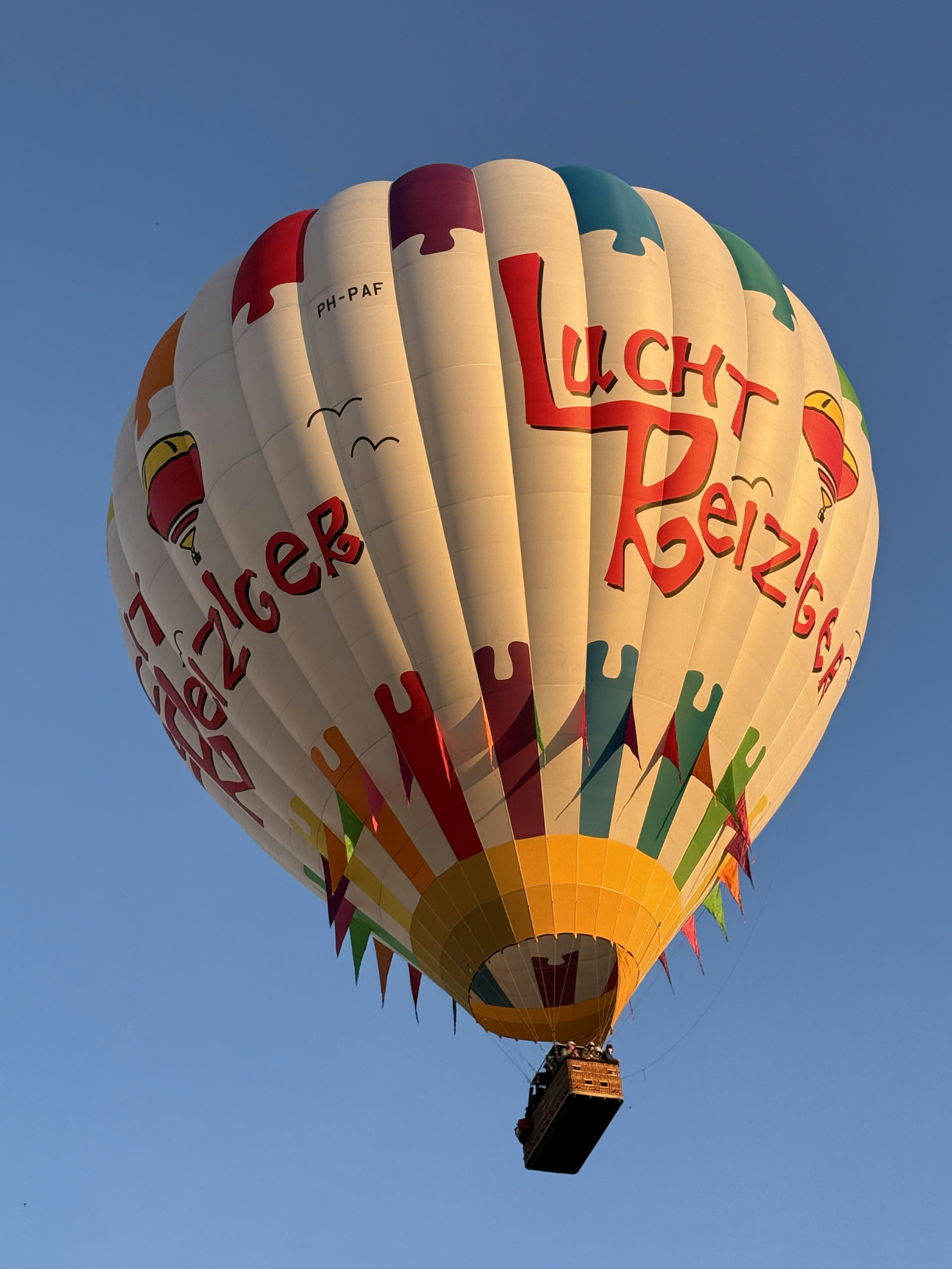 Balloon Lift: A Vibrant Hot-Air Soaring Over A Clear Sky