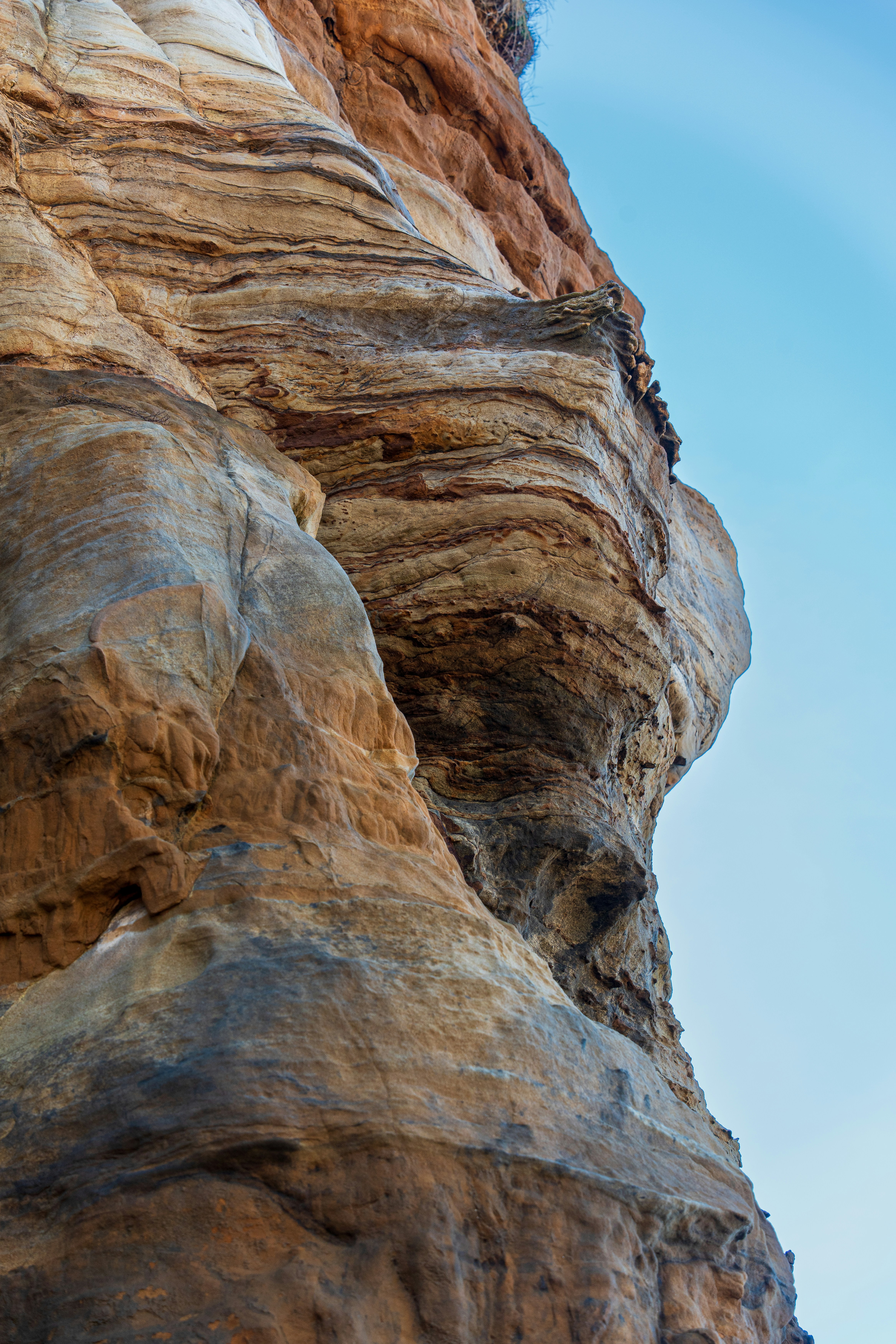 Strata Spiral: Weathered Sedimentary Walls Reaching Toward a Blue Sky