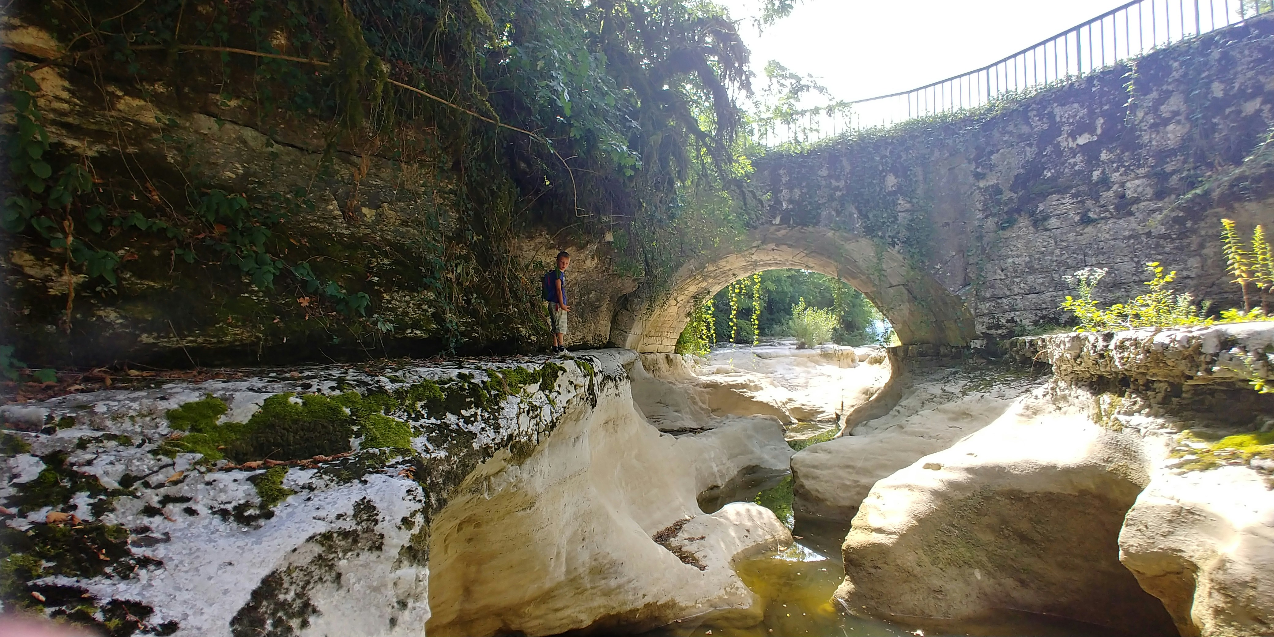 Stone Archway Over a Shallow River: Quiet Path Under a Bridge
