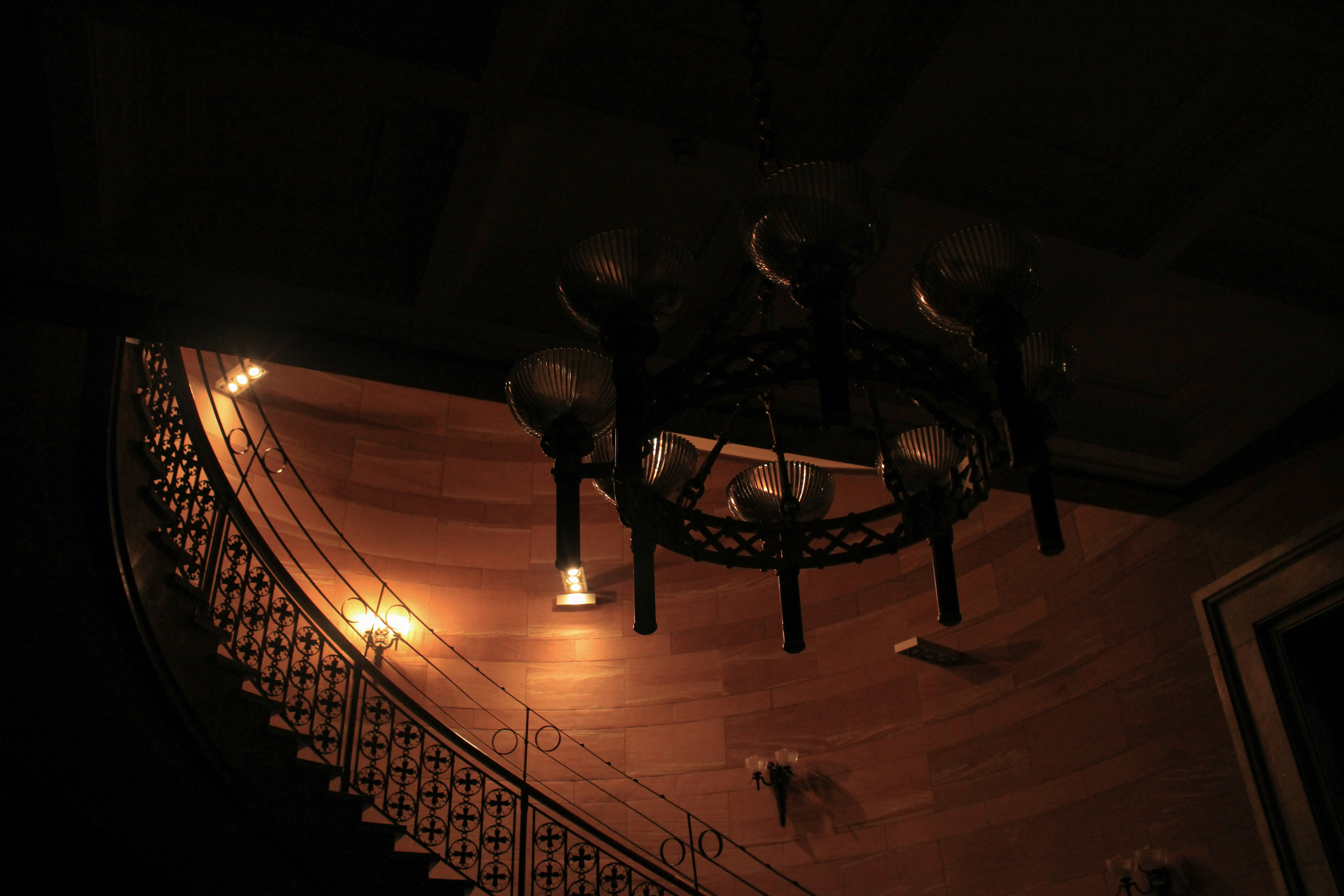 Dim Staircase Chandelier: Warm Glow in a Curved Hall