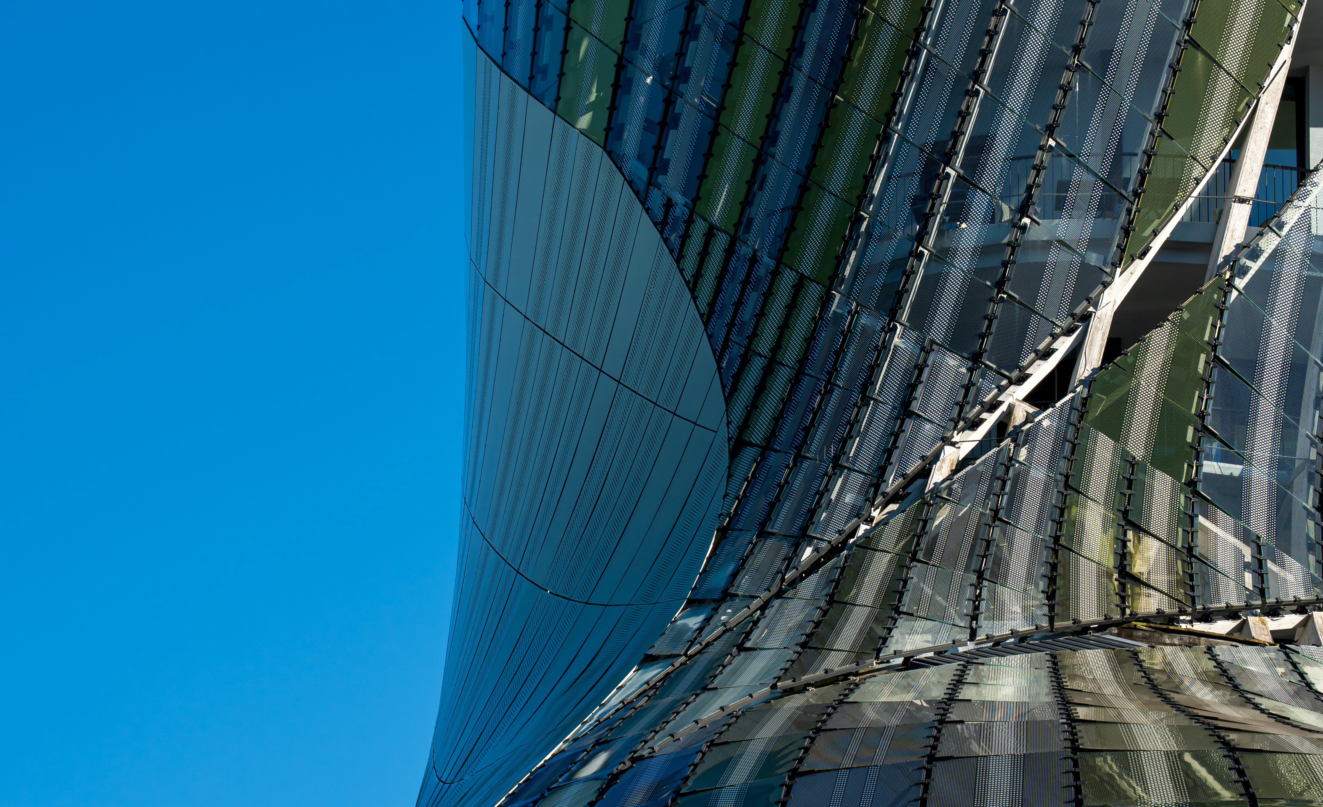 Curved Facade of a Modern Glass Building Reaching Toward the Sky