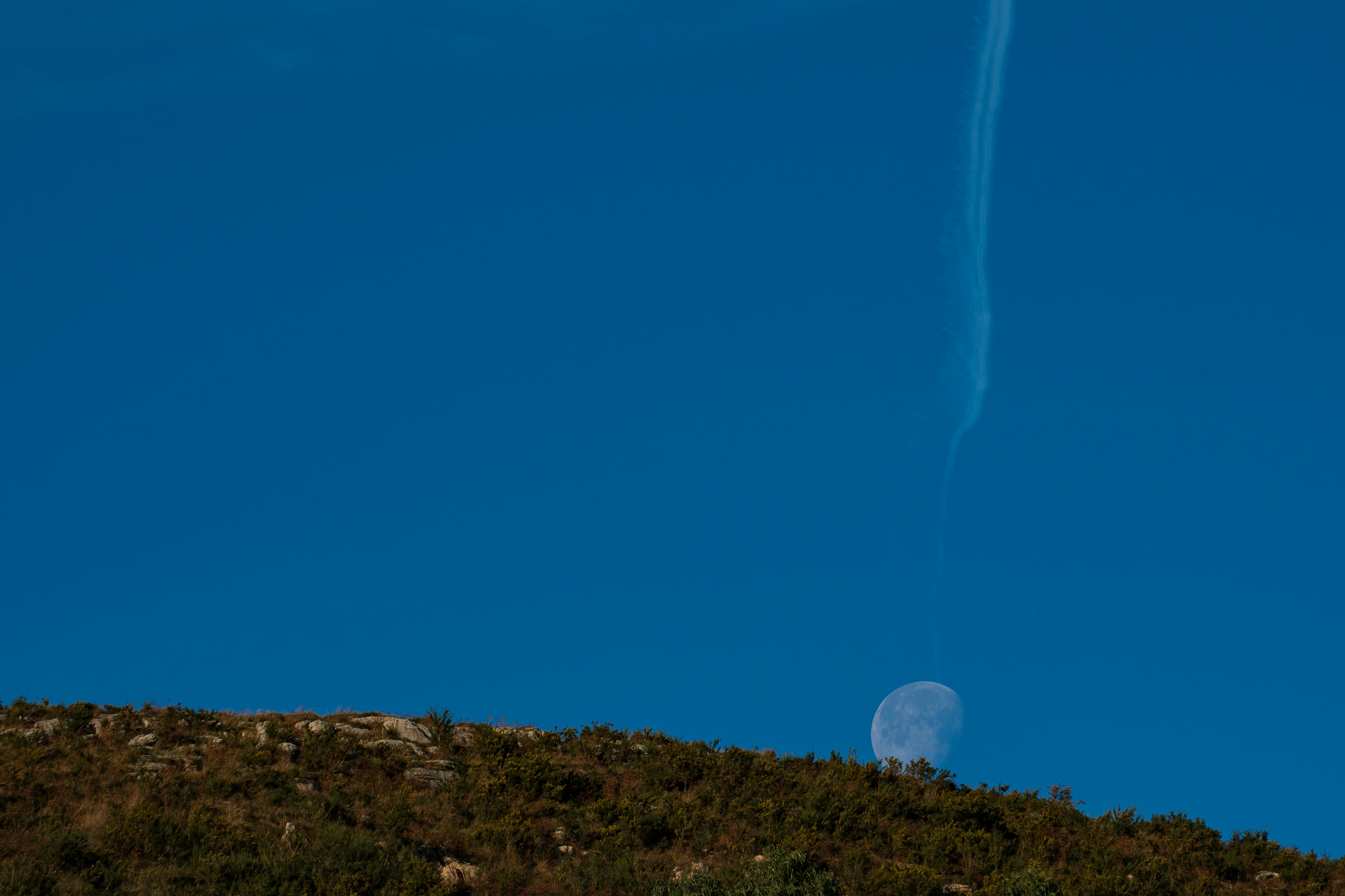 Moonrise Over the Hill: Clear Sky with Subtle Contrails