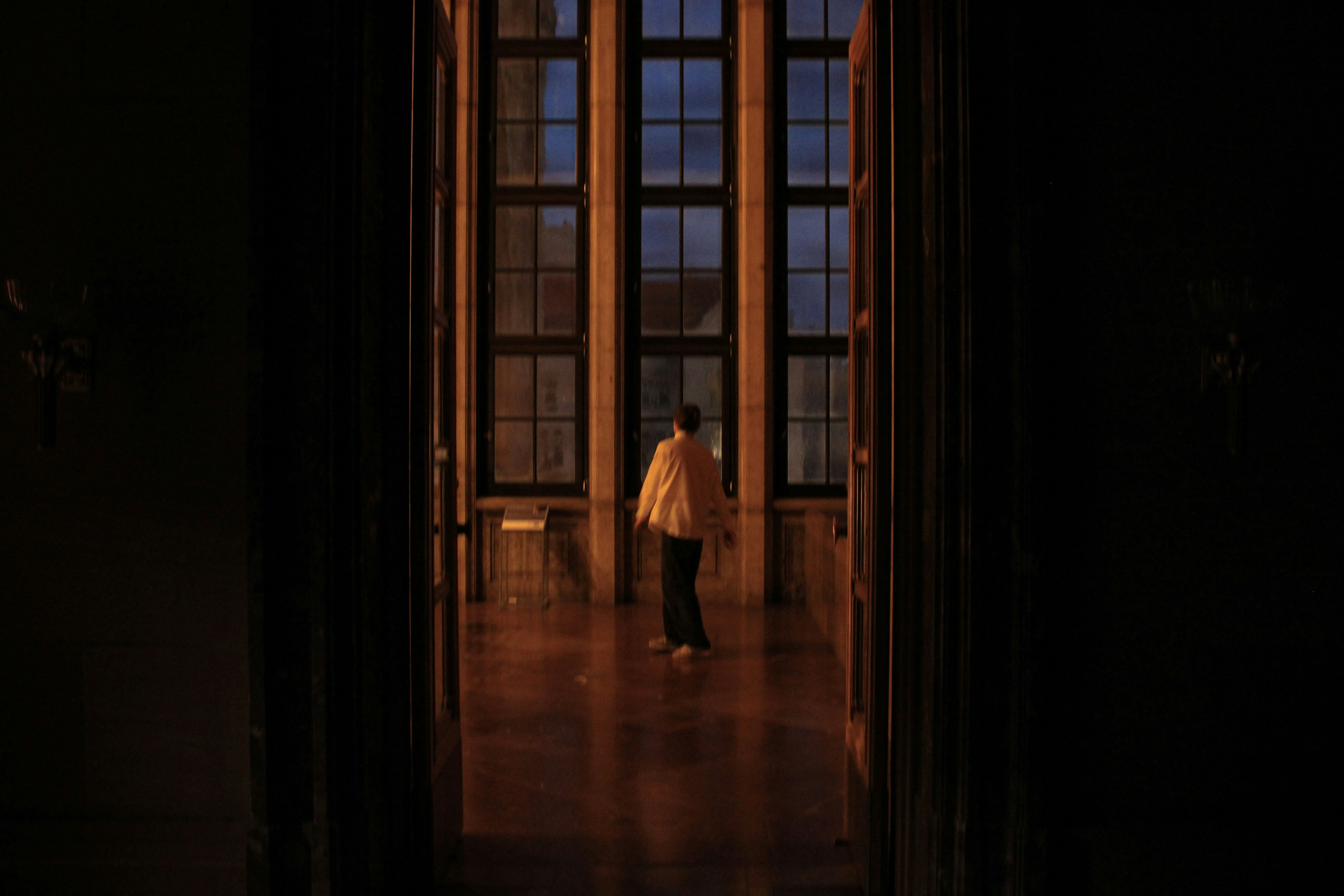 Silhouette in the Doorway: A Distant Dancer in a Velvet Room