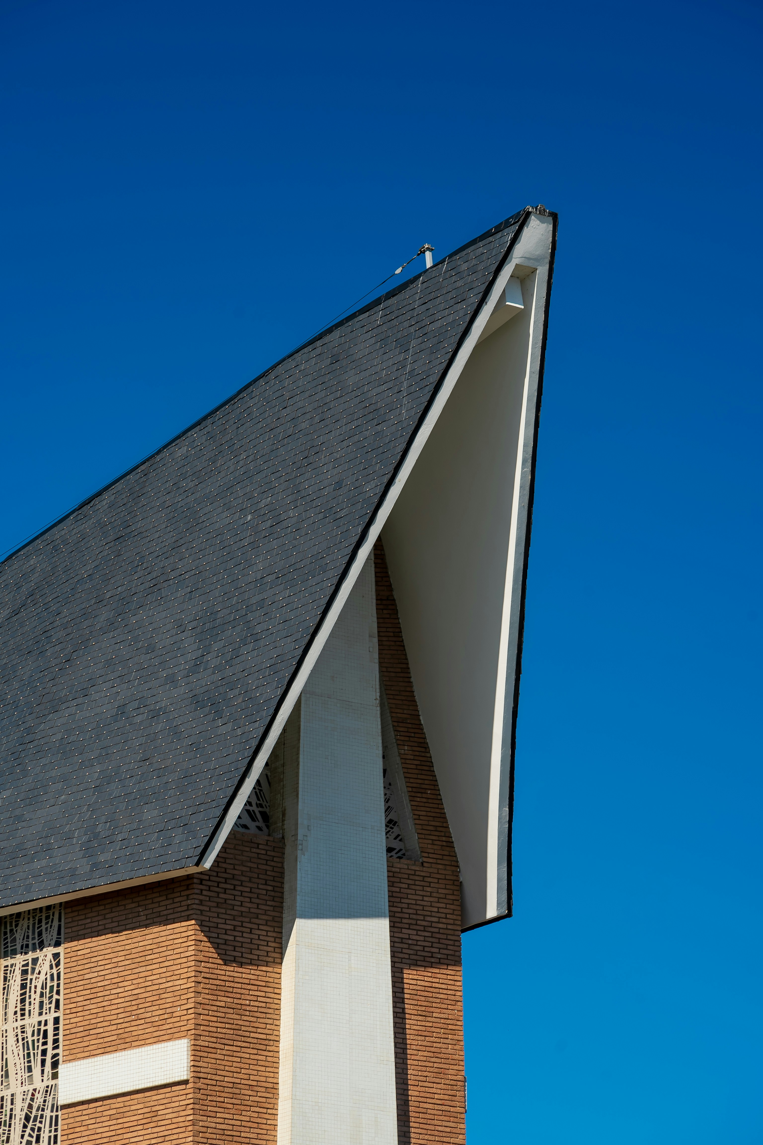 Architectural Peak: A Roof’s Steel Edge Against a Clear Blue Sky