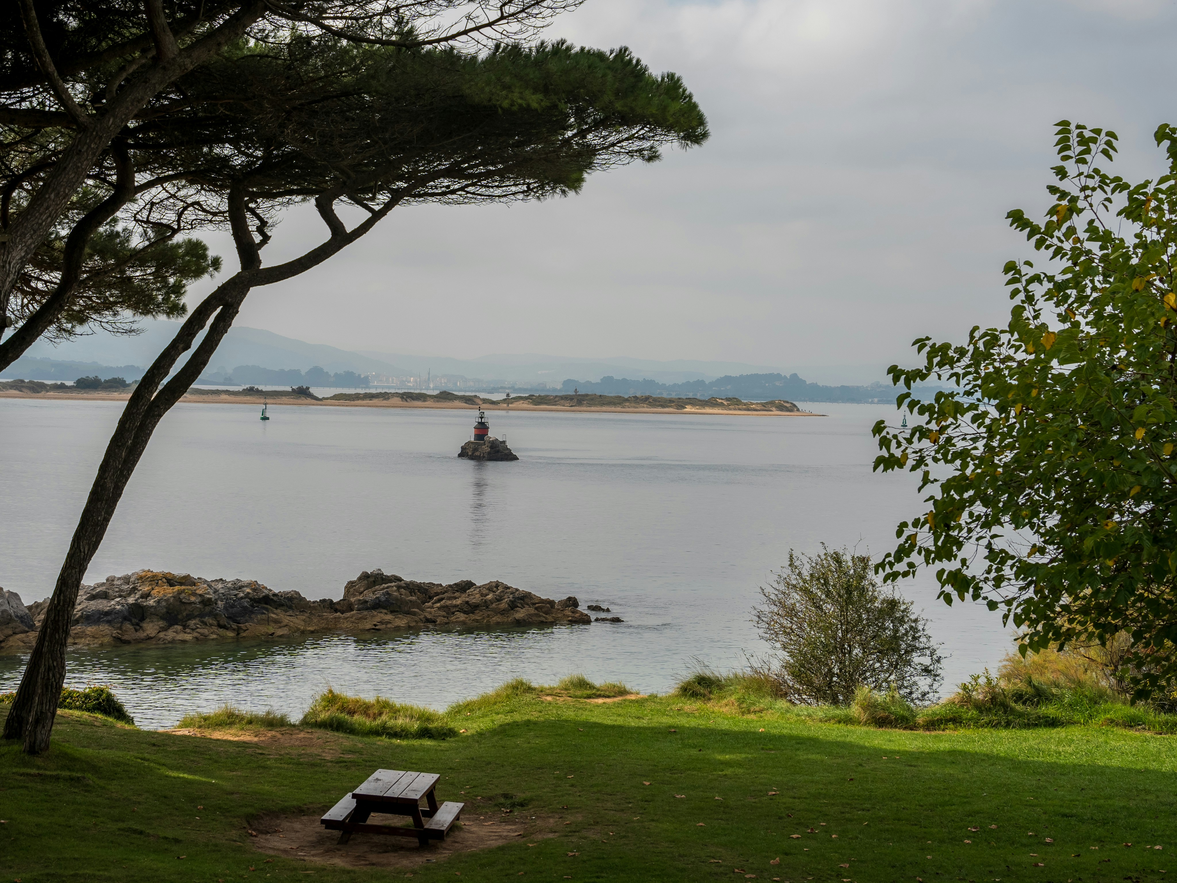 Stillness at the Shore: Lone kayaker amid a quiet bay