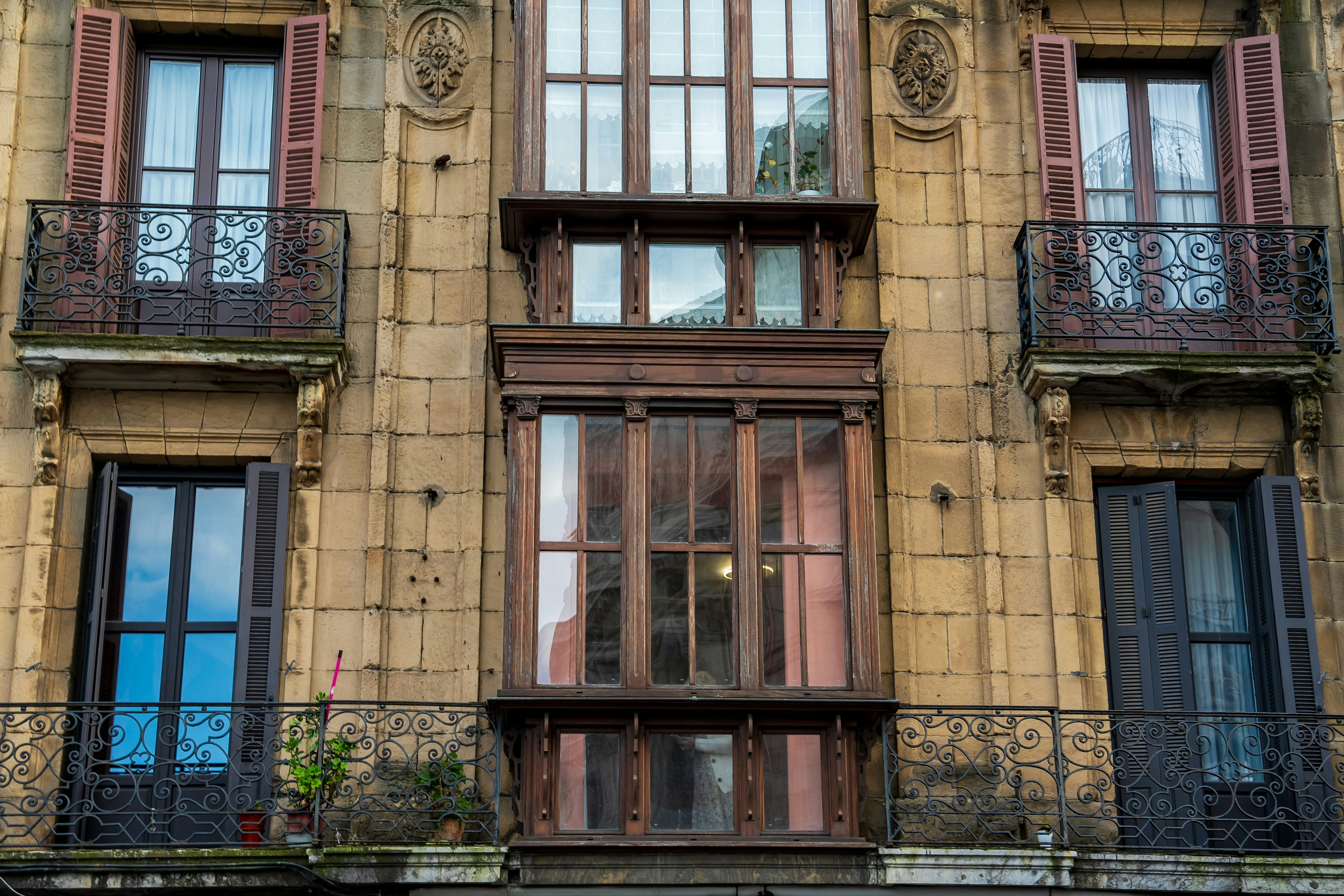 Ornate Balcony Facade: A Symphony of Limestone and Ironwork